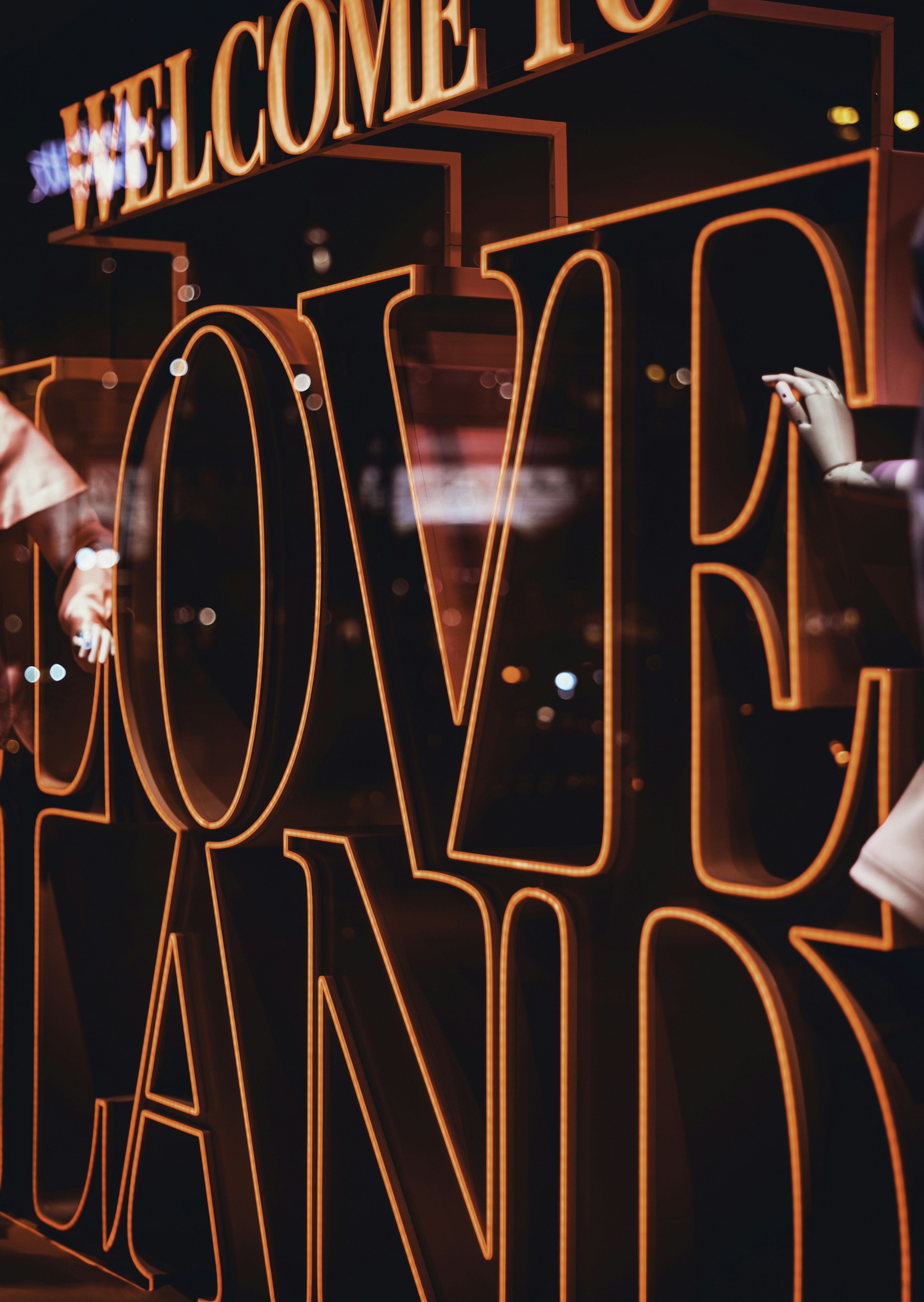 Neon Pulse of Love: Hands Reach for the Red Letters in Night