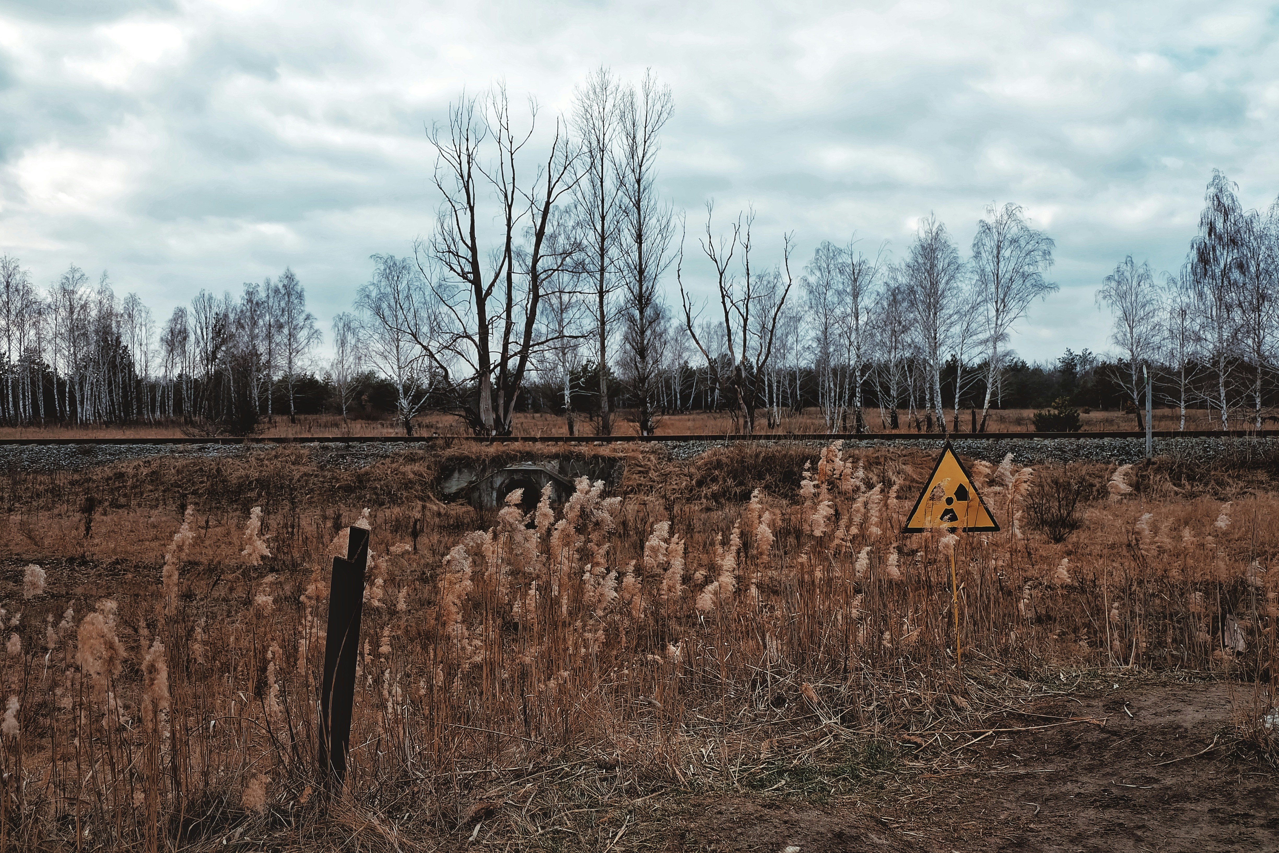 Desolate Field Echoes with Warning Sign