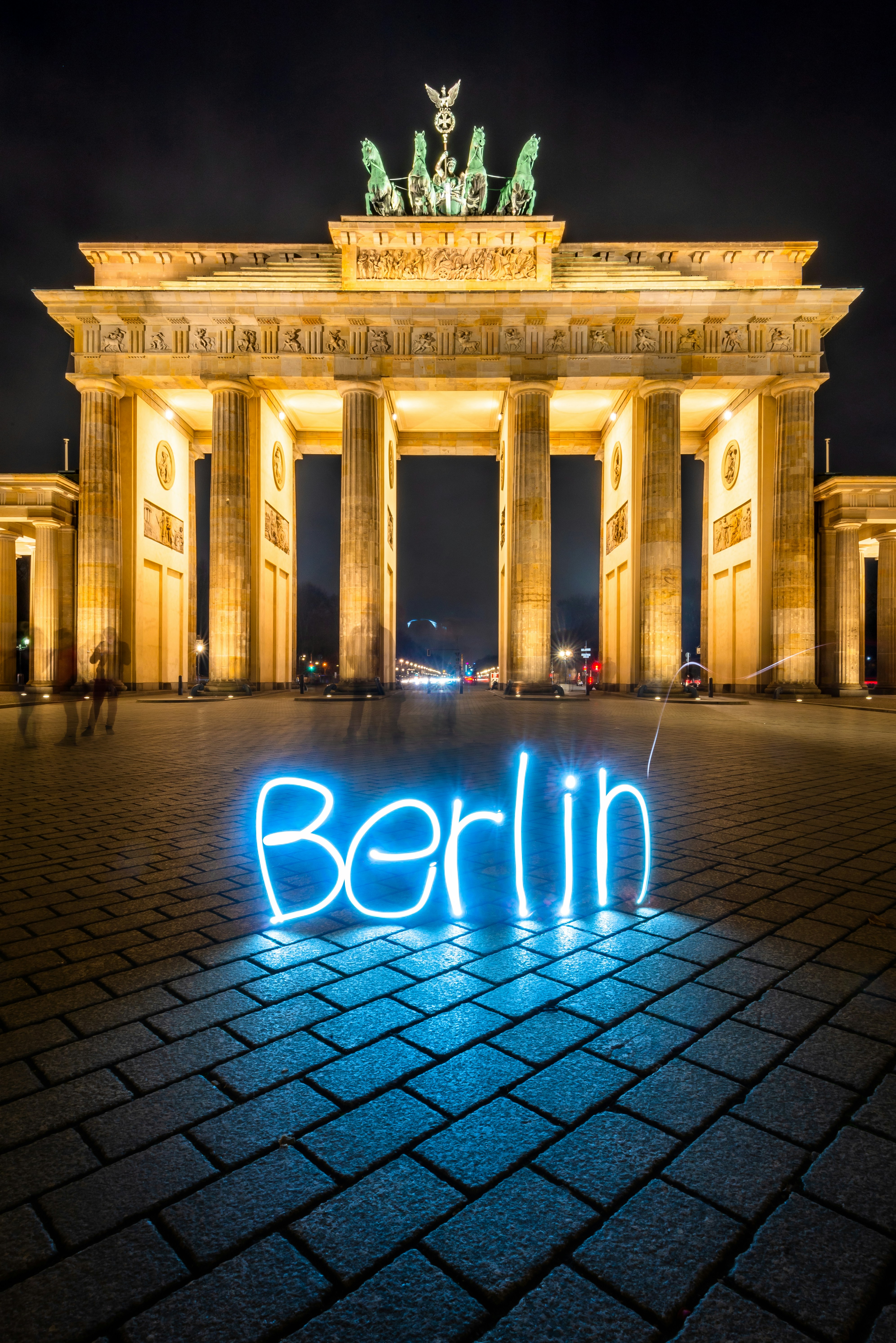 Brandenburger Tor in Berlin during nighttime. Long exposure light painting with the letters spelling Berlin.