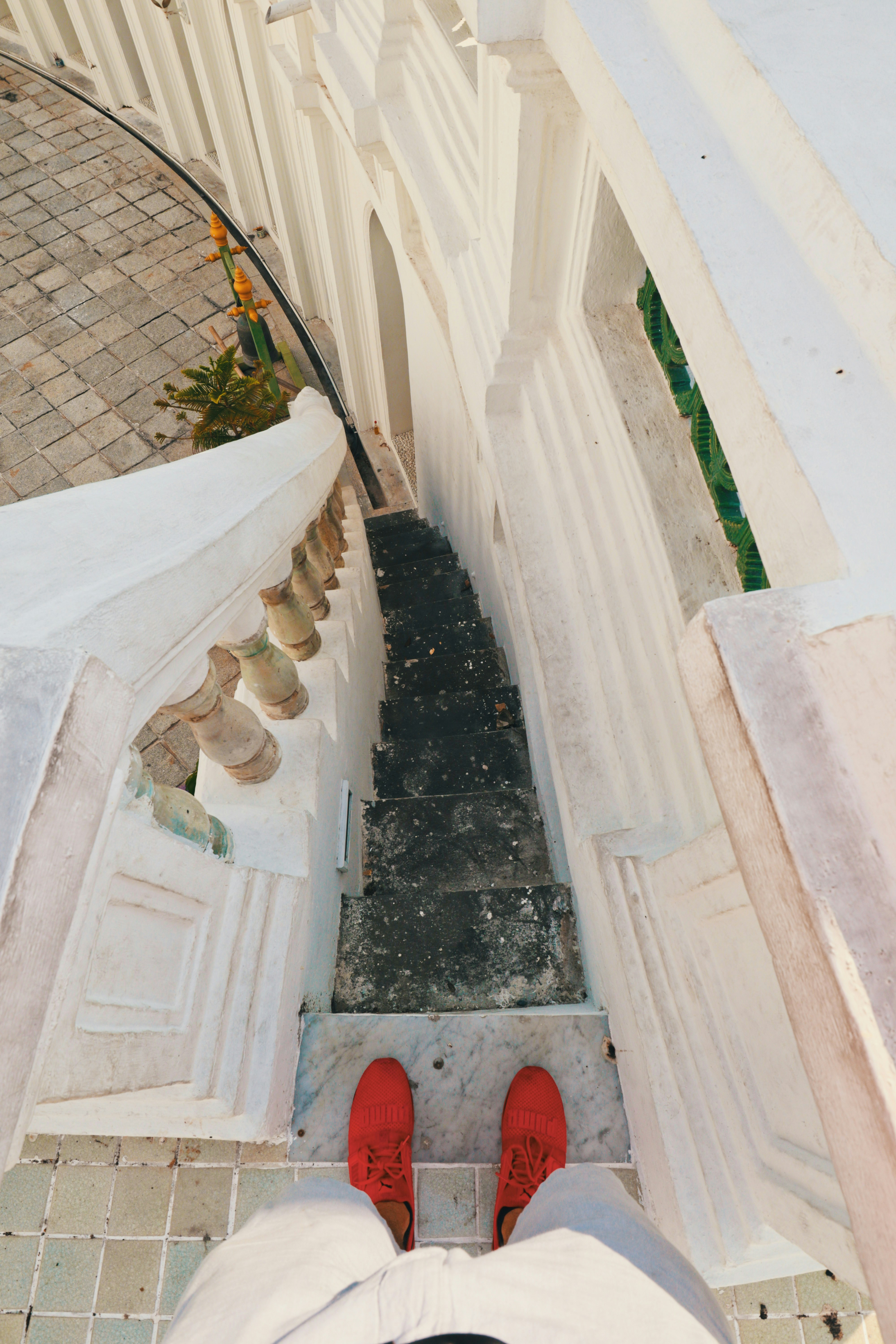 Red Shoes at the Threshold of an Ivory Stairwell
