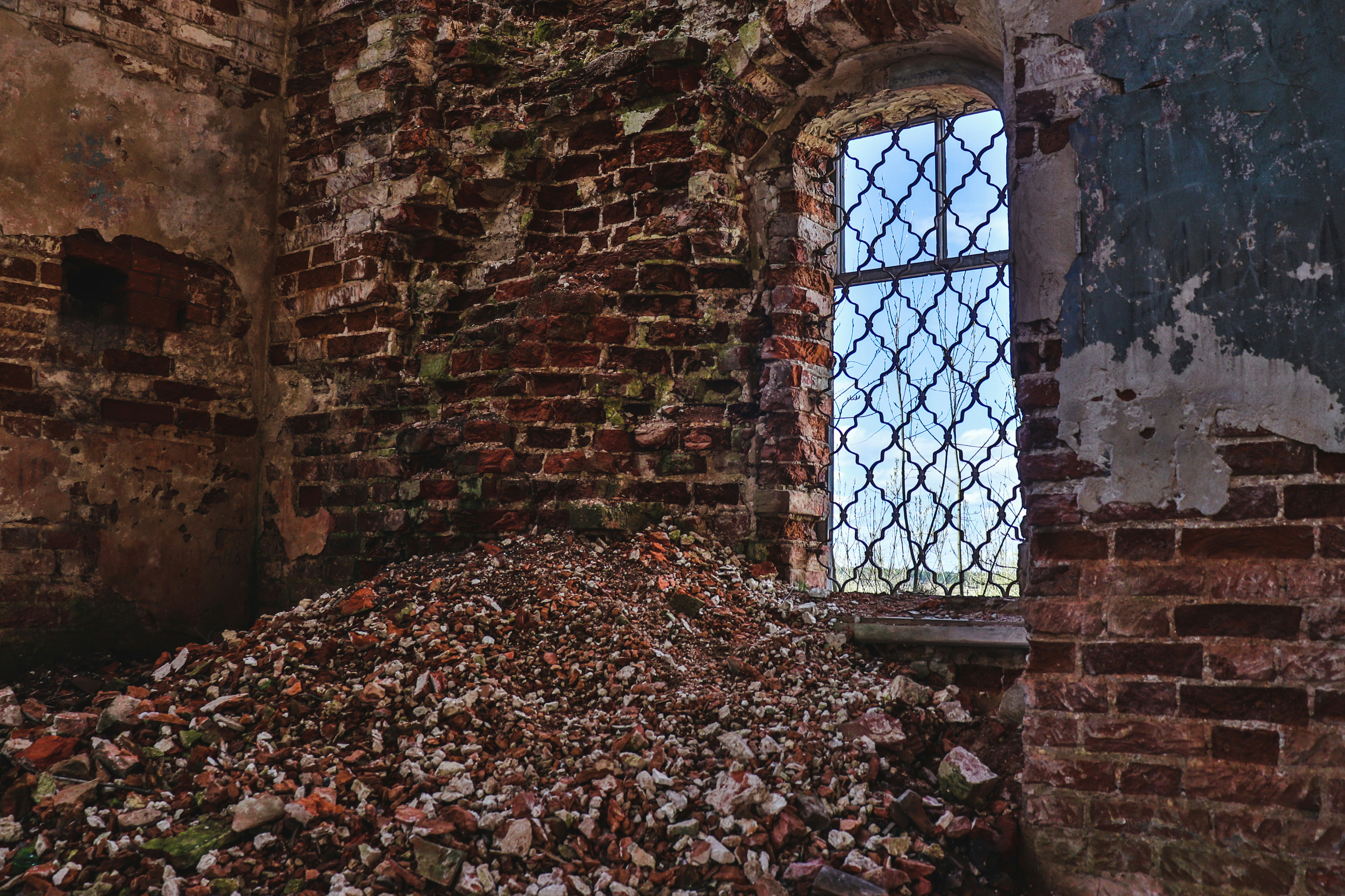 A pile of rubble next to a window in an old building photo – Free Blue ...