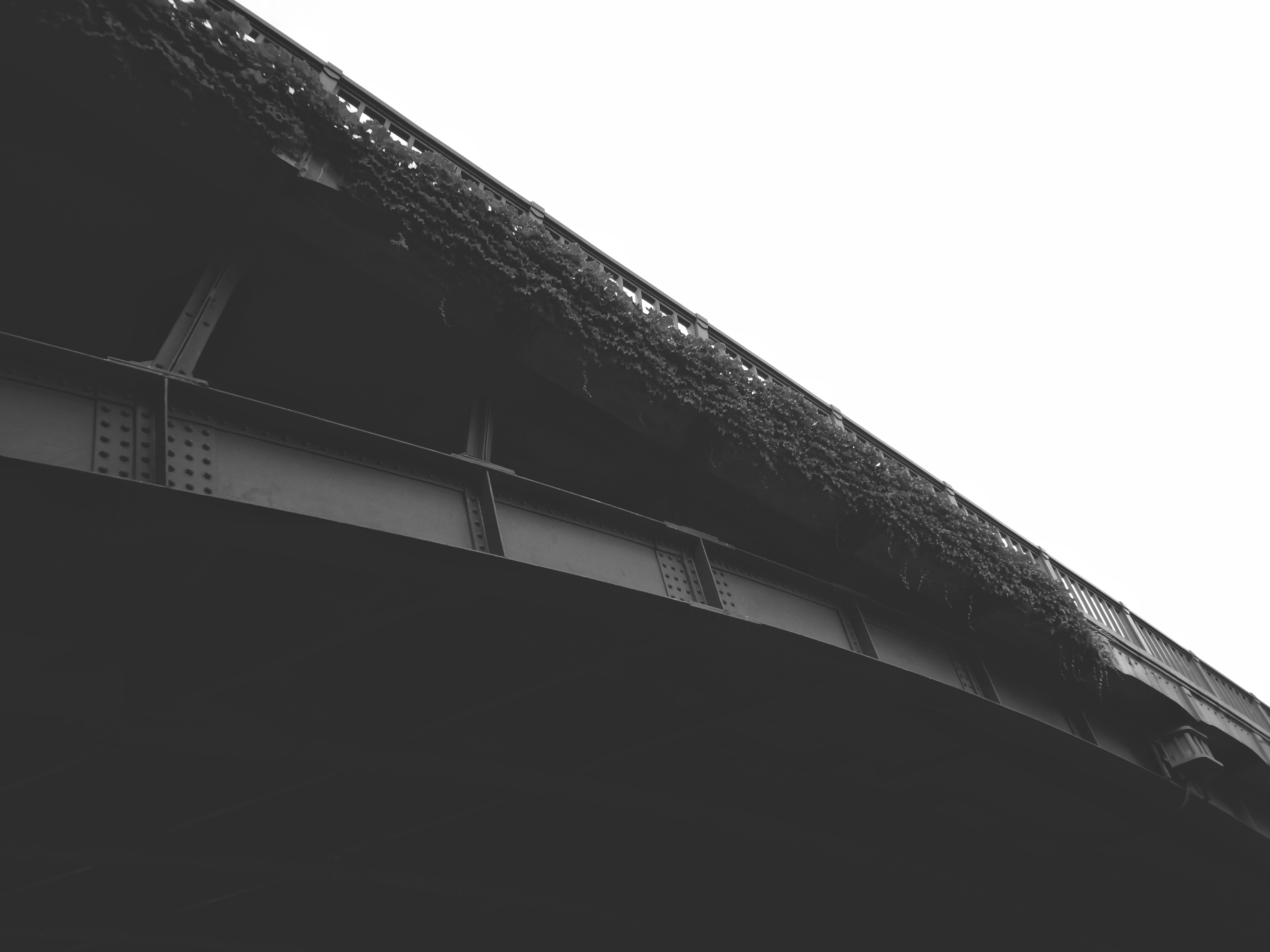 A close-up view of a weathered overpass with moss and decay, highlighting the contrast between nature and urban infrastructure.