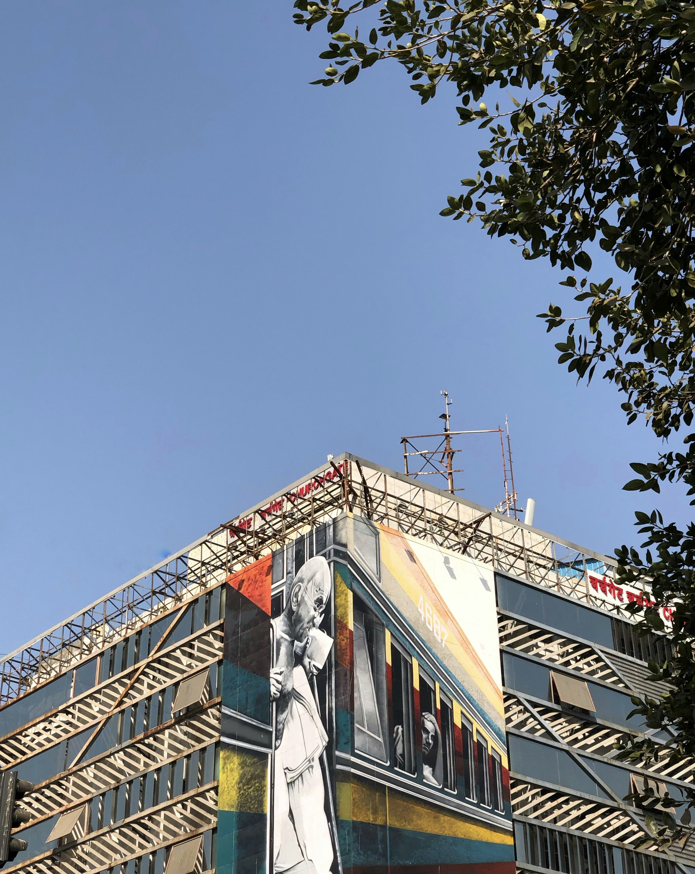 Facade Mosaic: A mural-clad office tower under a crisp blue sky