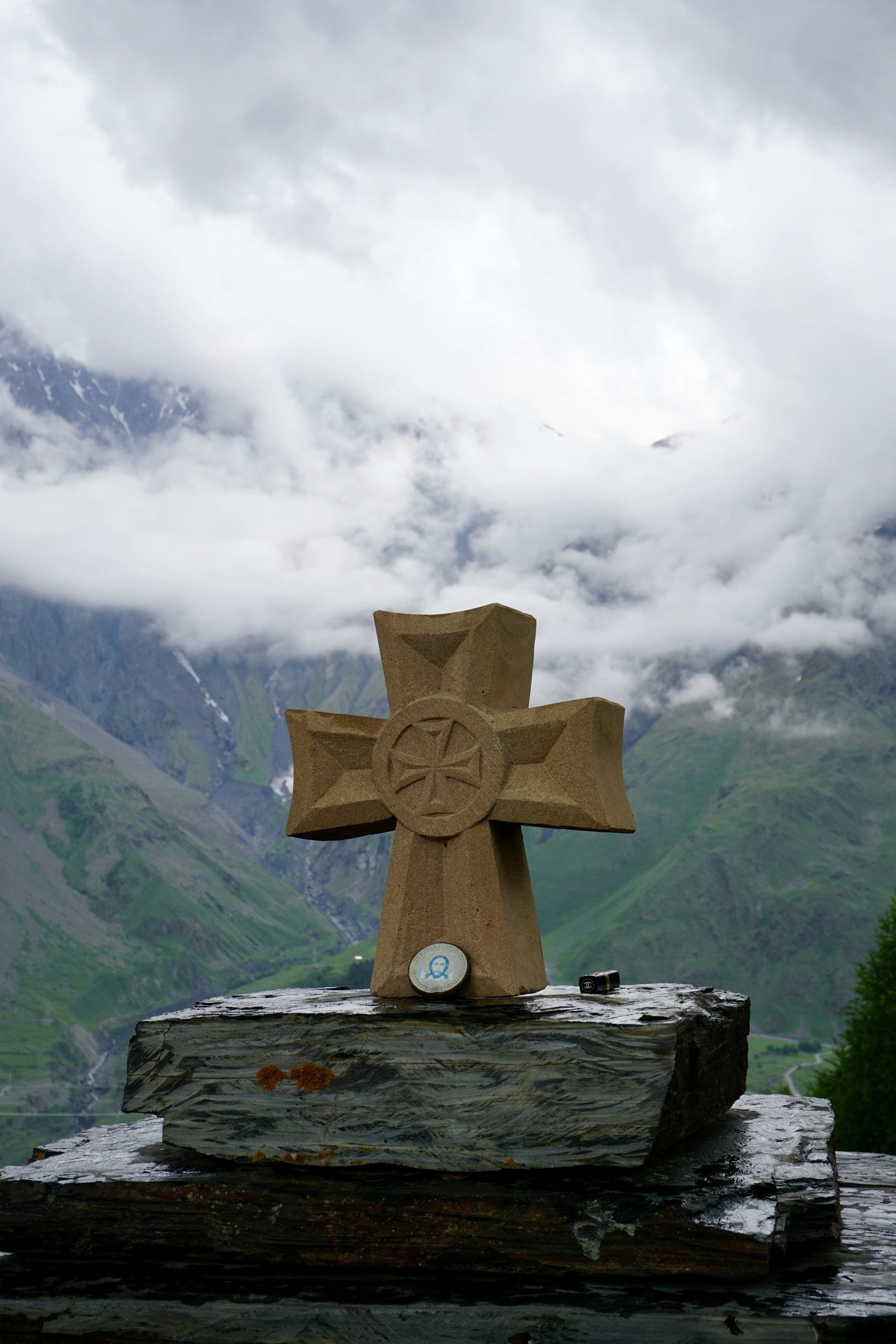 Stone Cross on a Weathered Plinth Over a Misty Alpine Valley