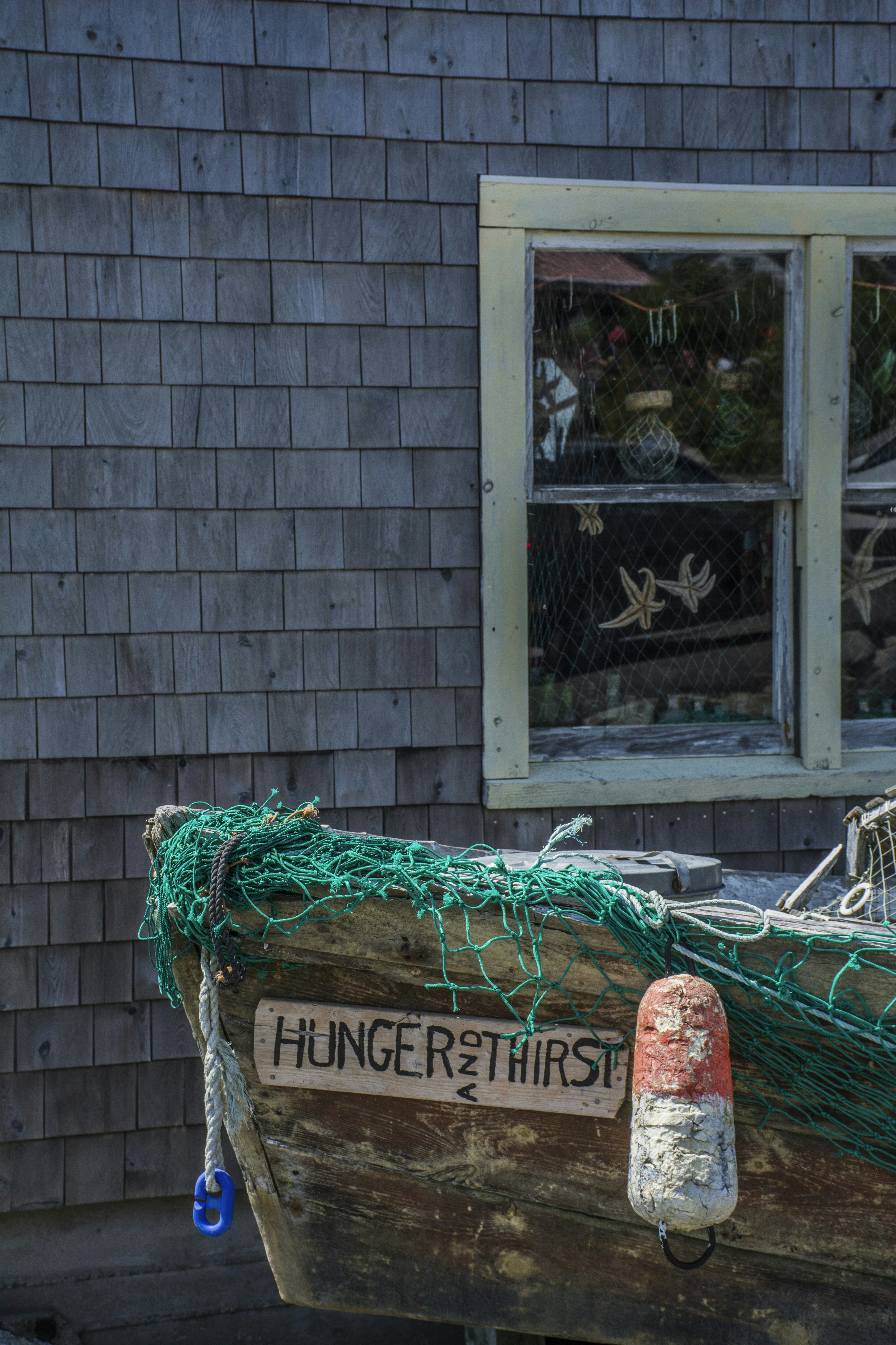 Hunger and Thirst on a Weathered Hull by a Shingled Wall