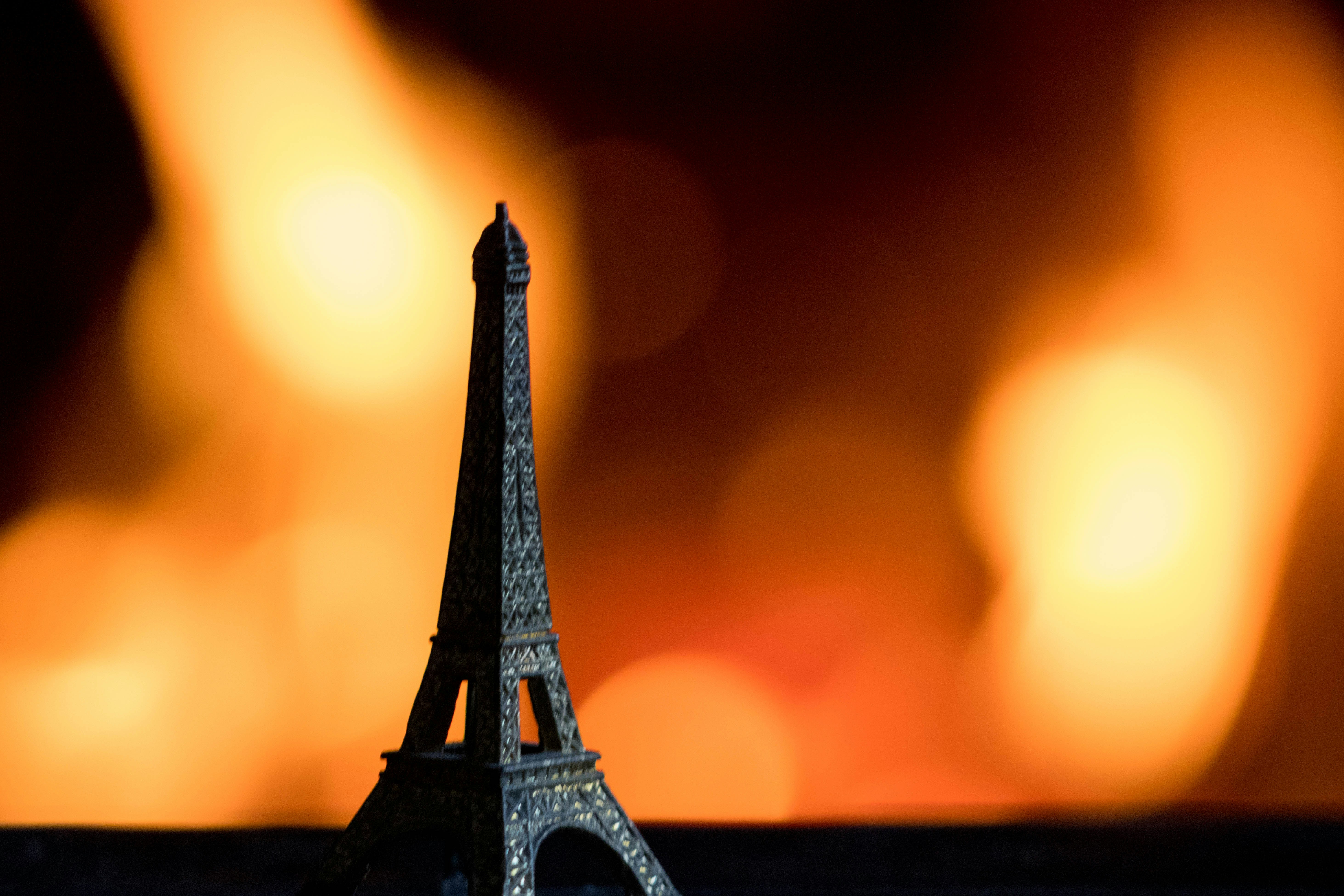 Miniature Tower, Grand Flames: A Quiet Eiffel Silhouette Against Firelight