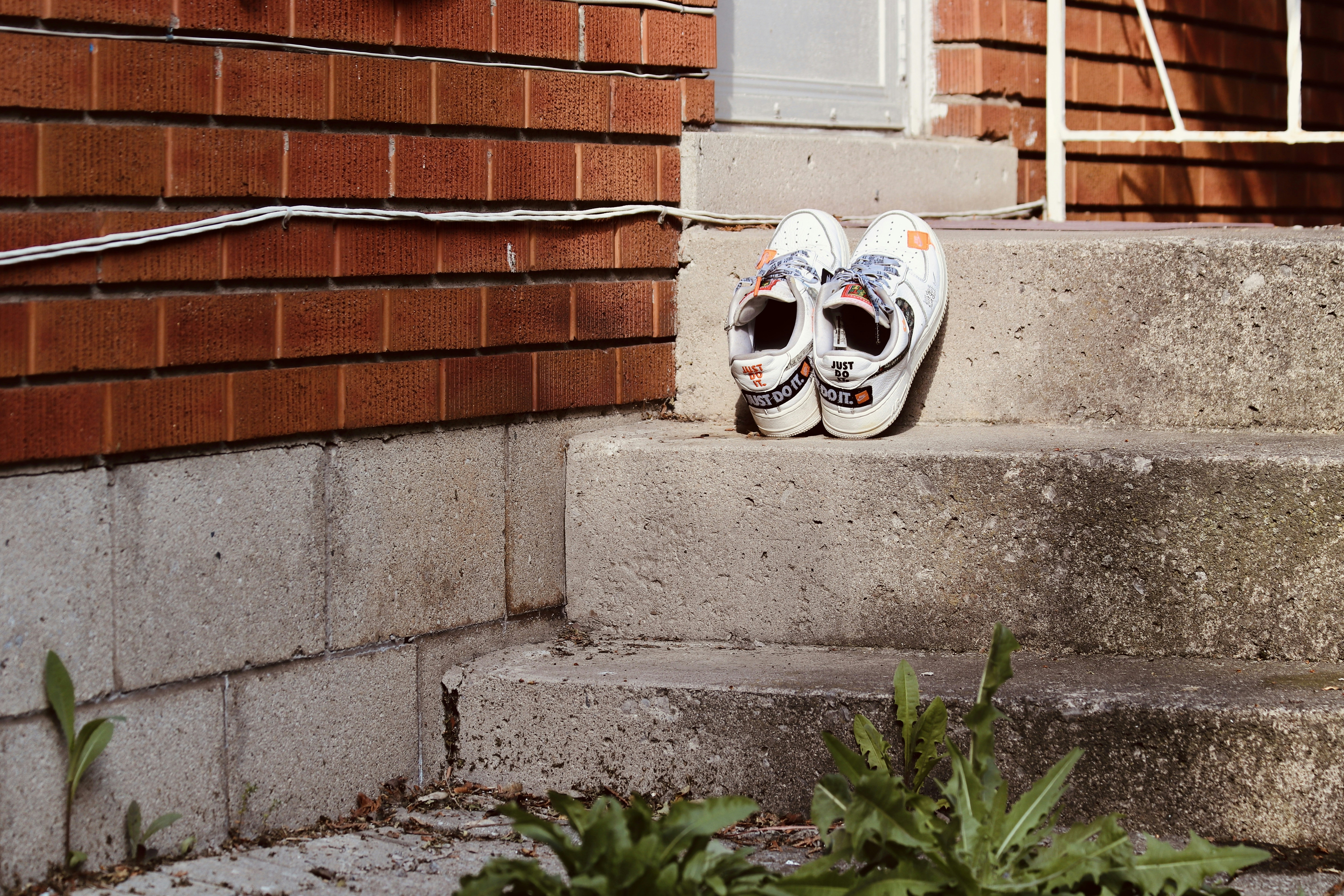 white and red running shoes on gray concrete stairs