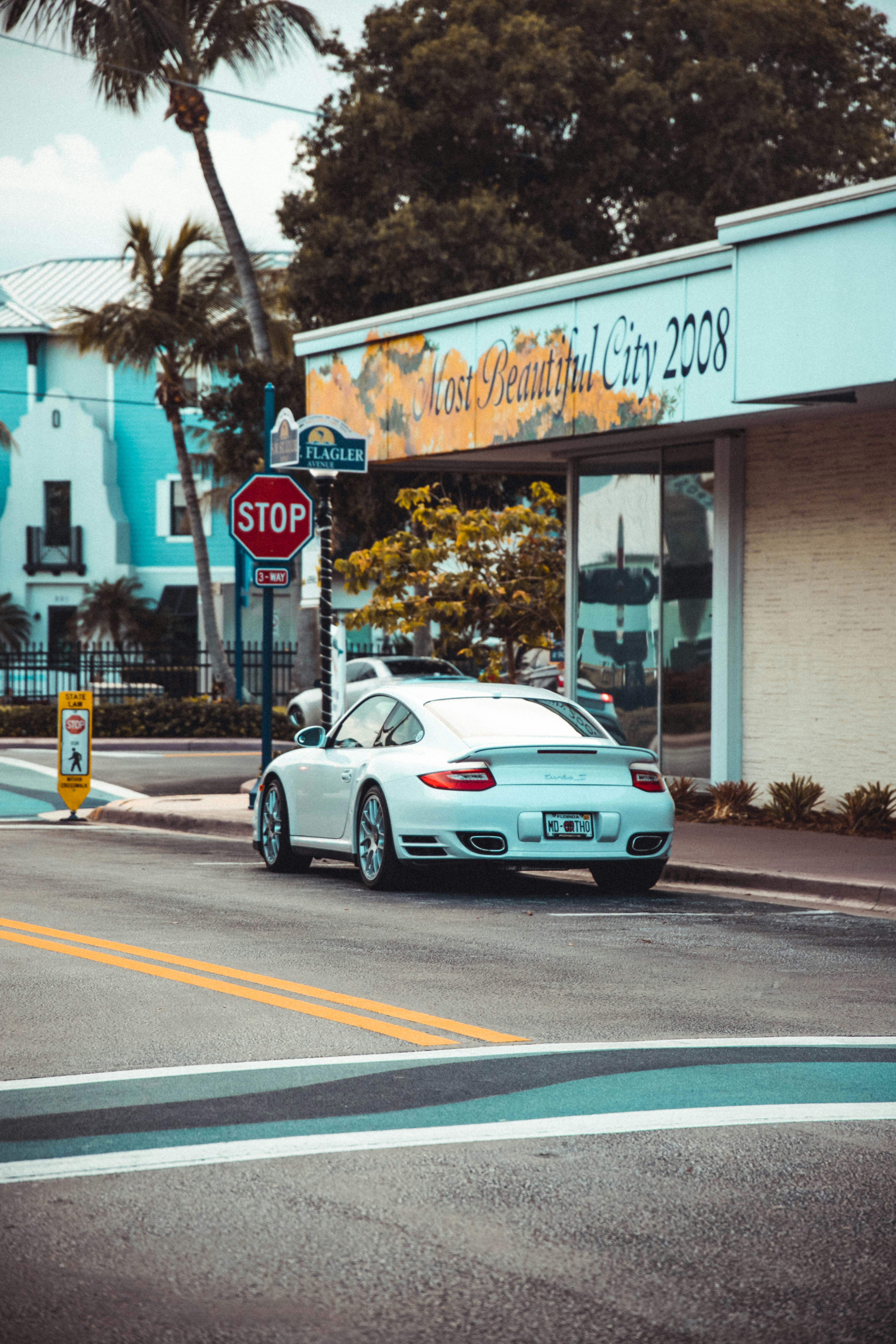 A White Porsche parked on the side of the road