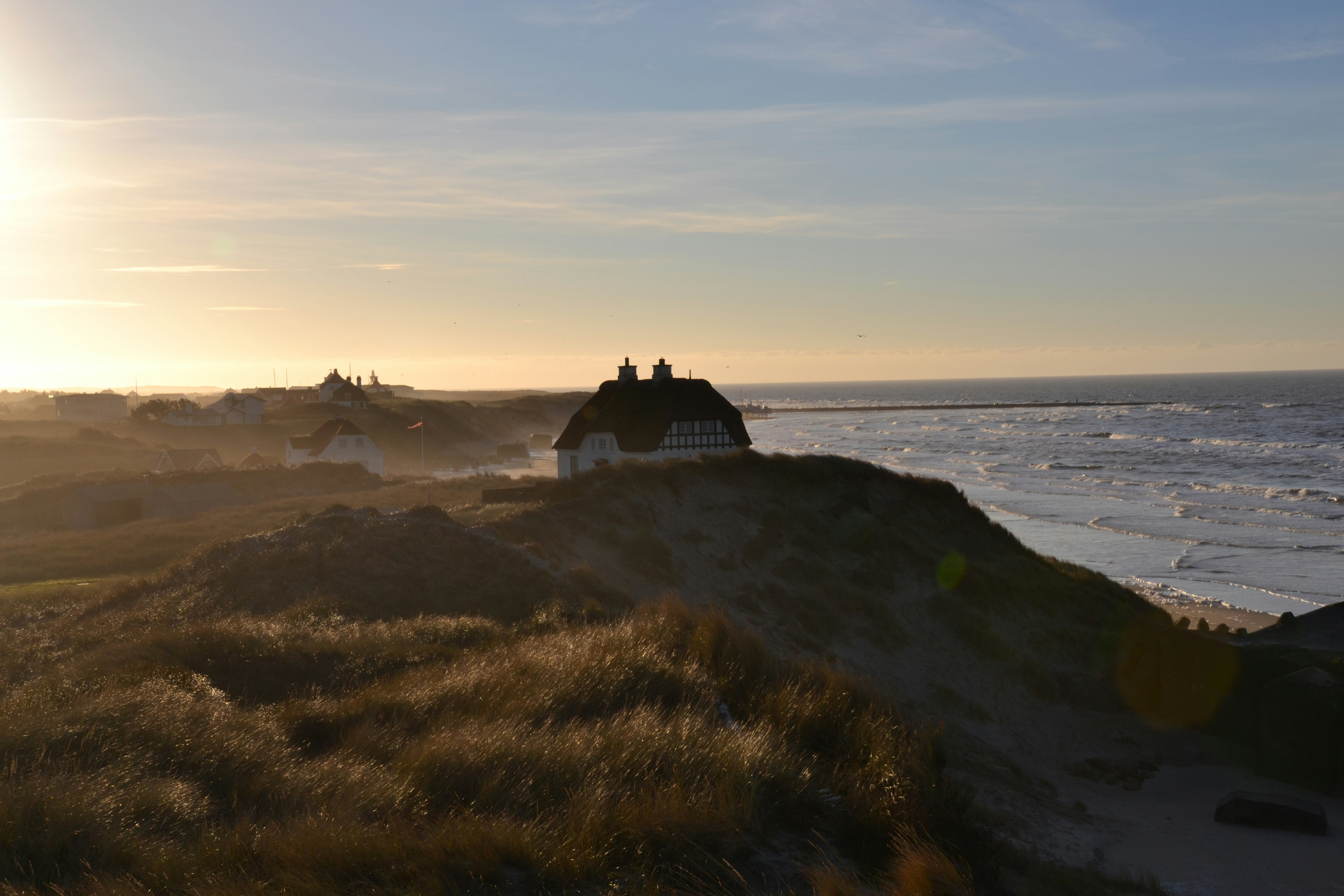 Golden Hour on the Dune Ridge: Seaside Homes Against a Quiet Sea