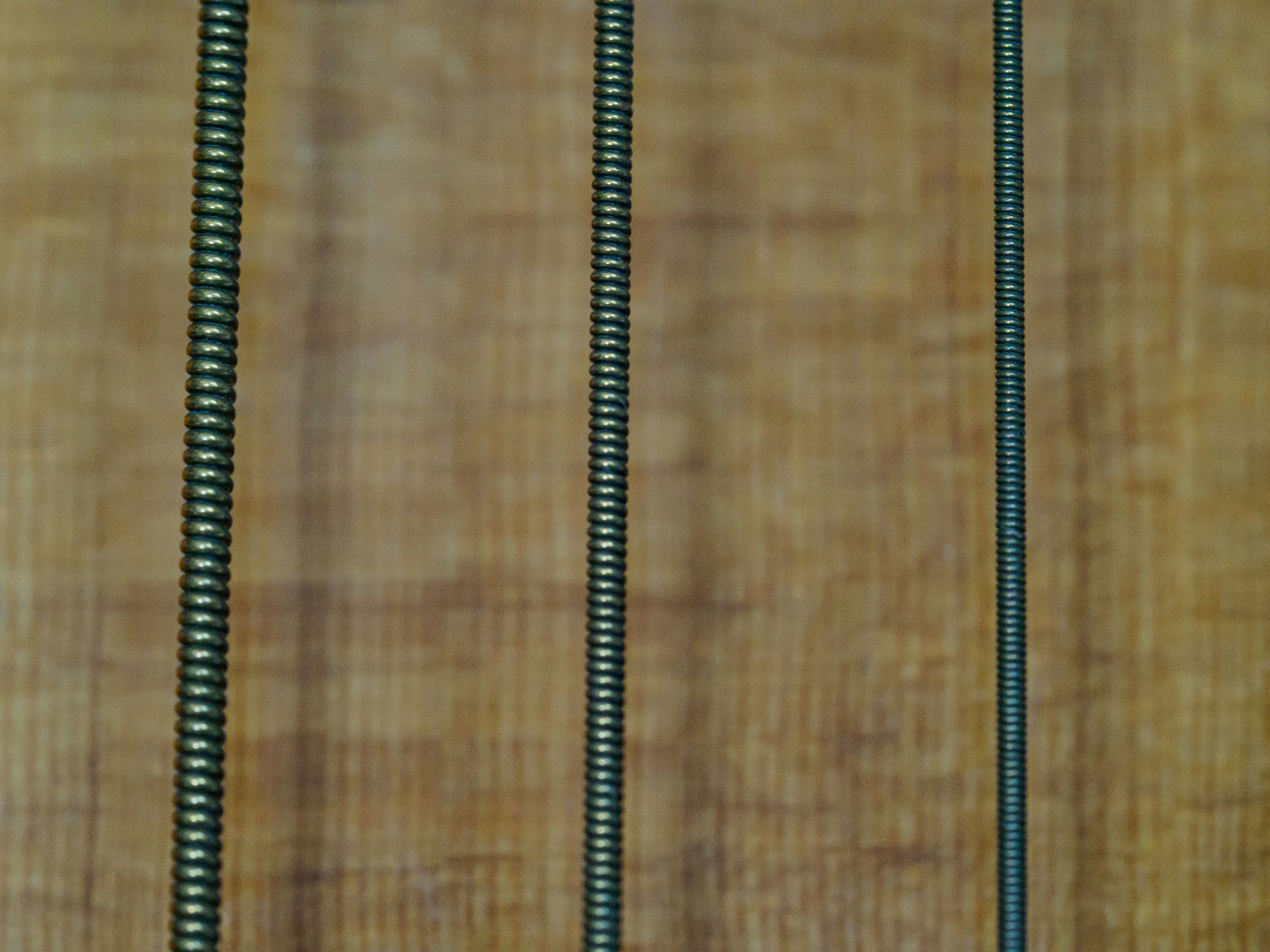 close up, bokeh, blur, macro, blurred background, close focus,  acoustic guitar, guitar, string, steel string, coil string, coil, 