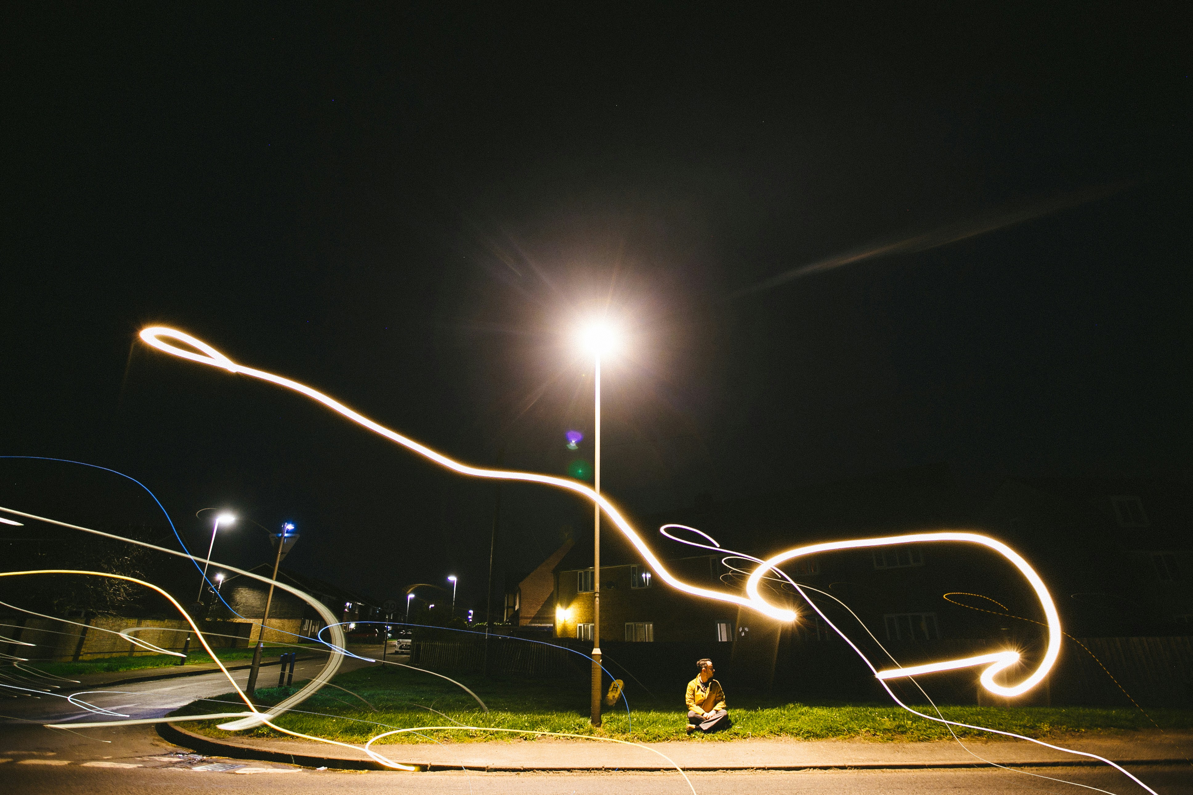 Haloed Night: Light Trails Weave Around a Quiet Figure