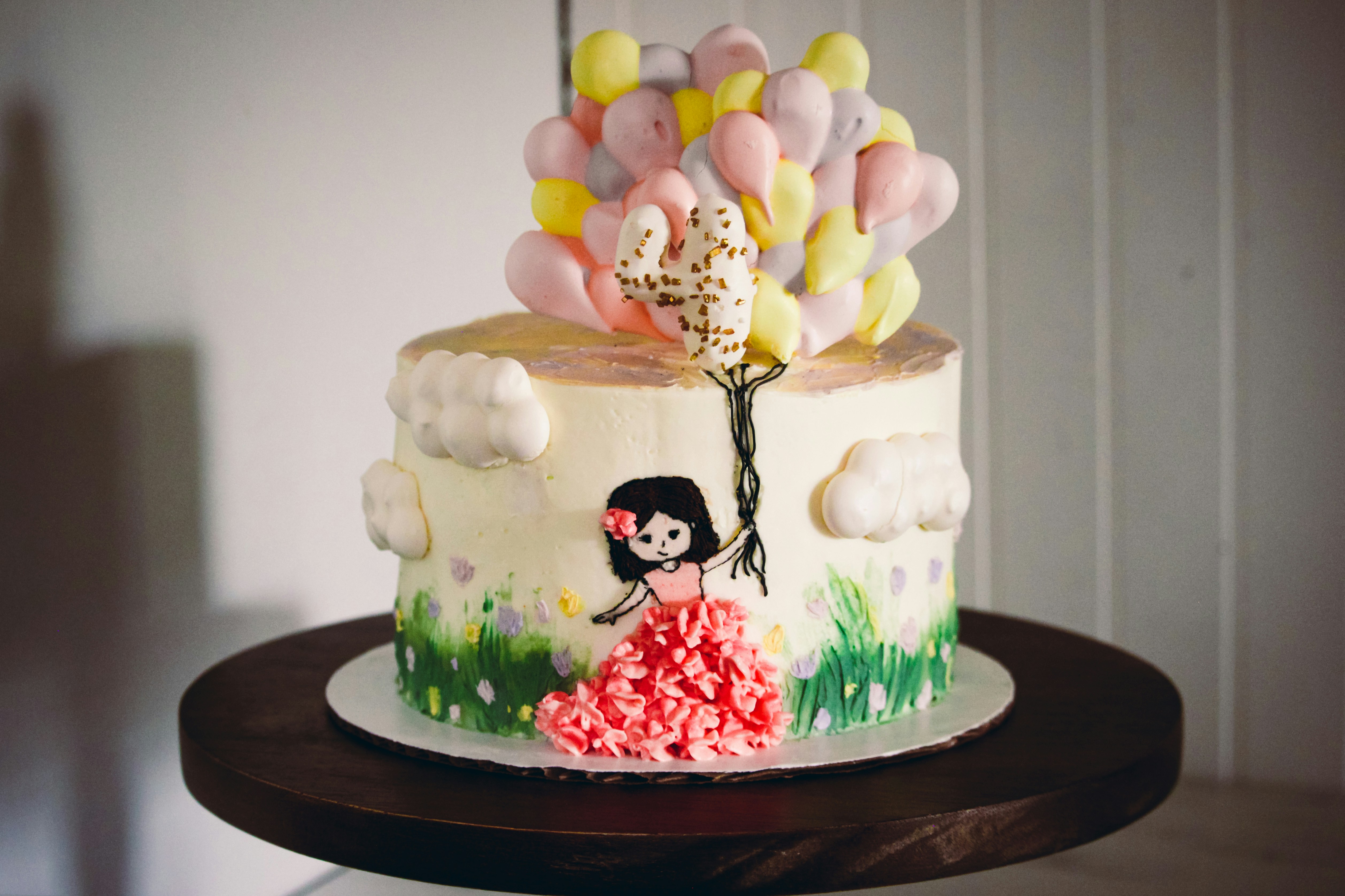 Balloon-Top Birthday Cake with a Whimsical Figurine