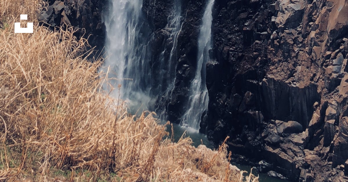 昼間の青空の下、茶色の岩山の滝の写真 Unsplashの灰色の無料画像