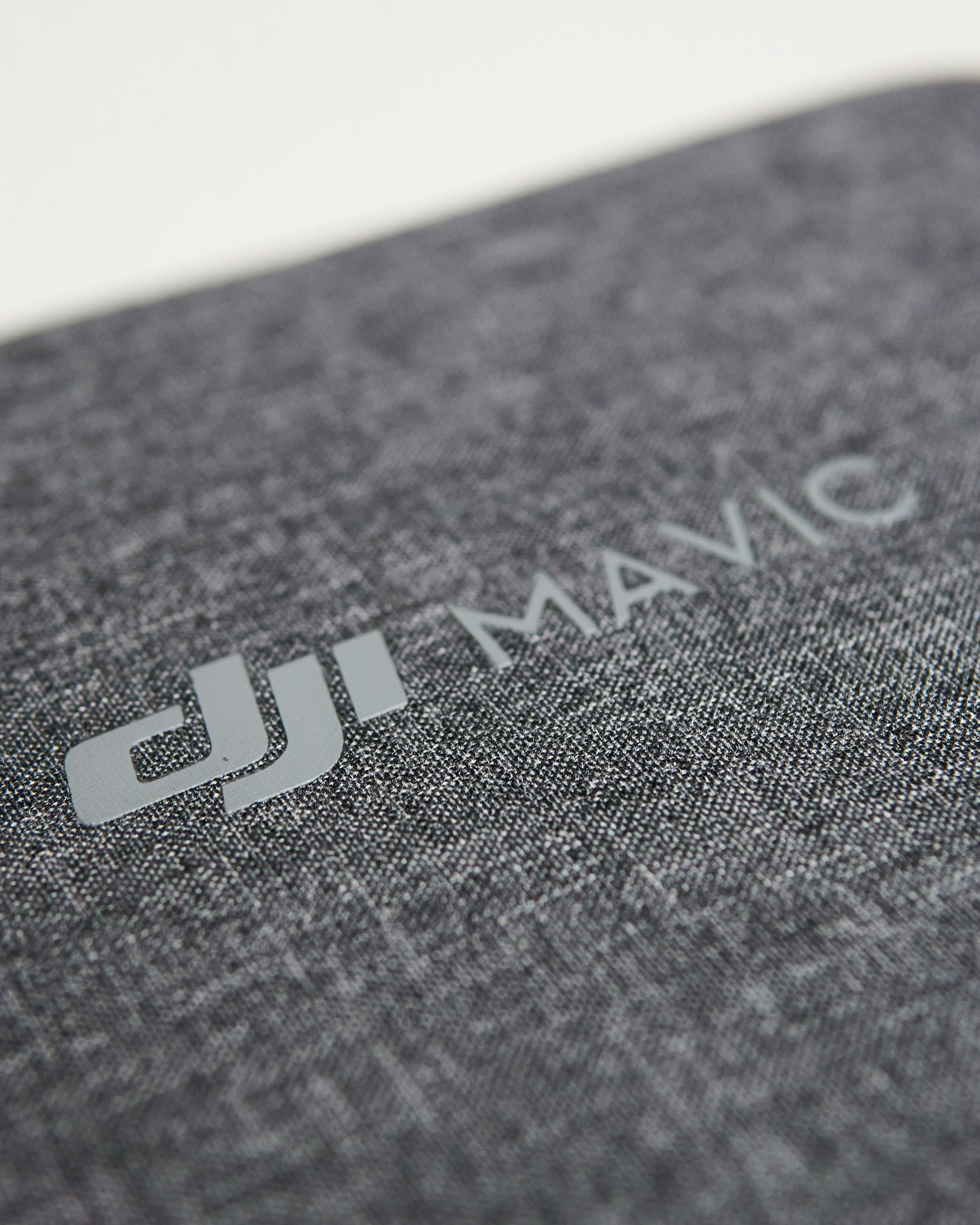 Logo Close-Up: Dense Fabric Texture and Brand Mark on a Lens Cover
