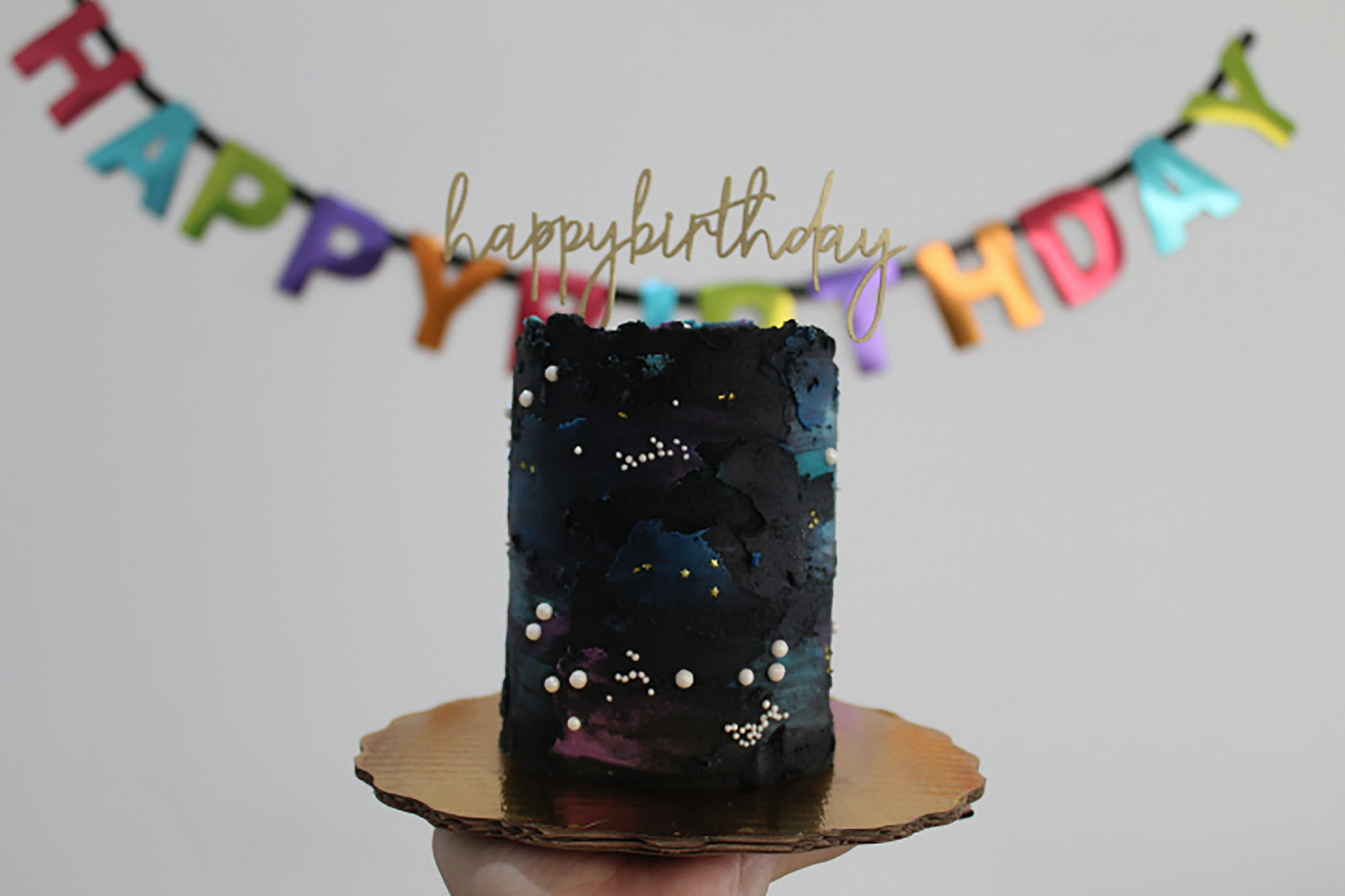 Starfield Slice: A Galaxy-Themed Cake Framed by a Rainbow Birthday Banner