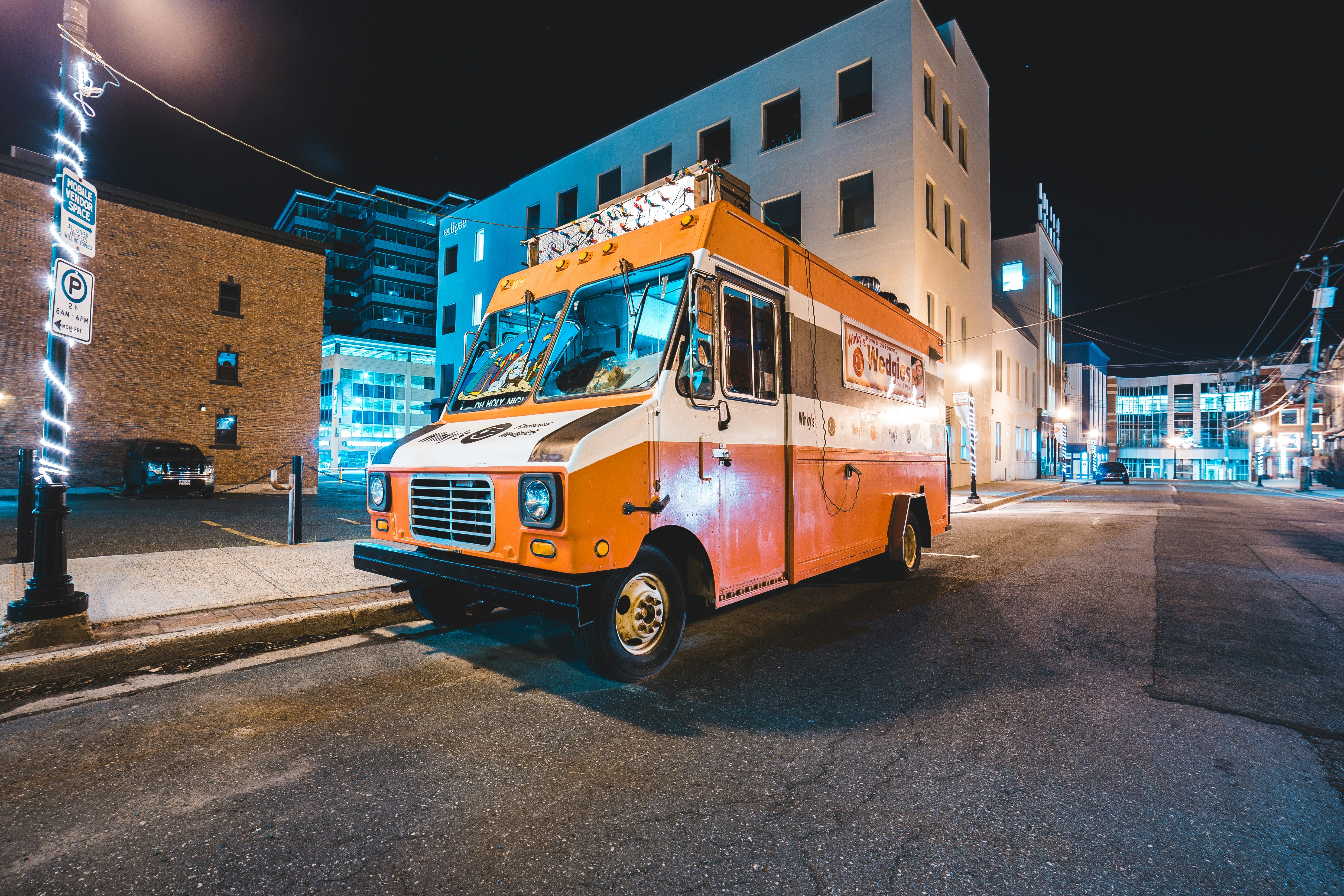 Neon-Warmed Orange Food Truck Anchors a Quiet Downtown Night