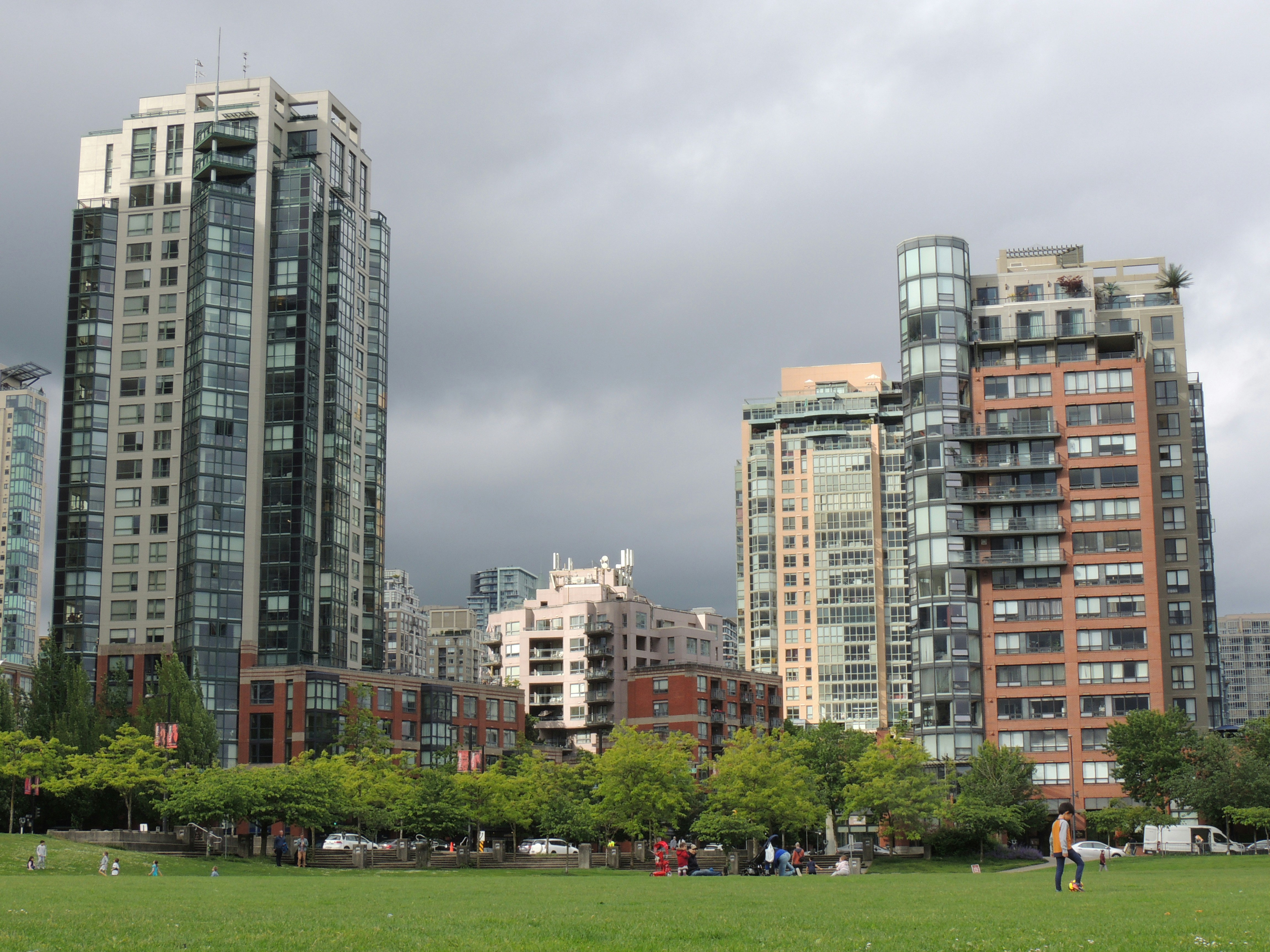 Green grass field near high rise buildings during daytime photo – Free ...