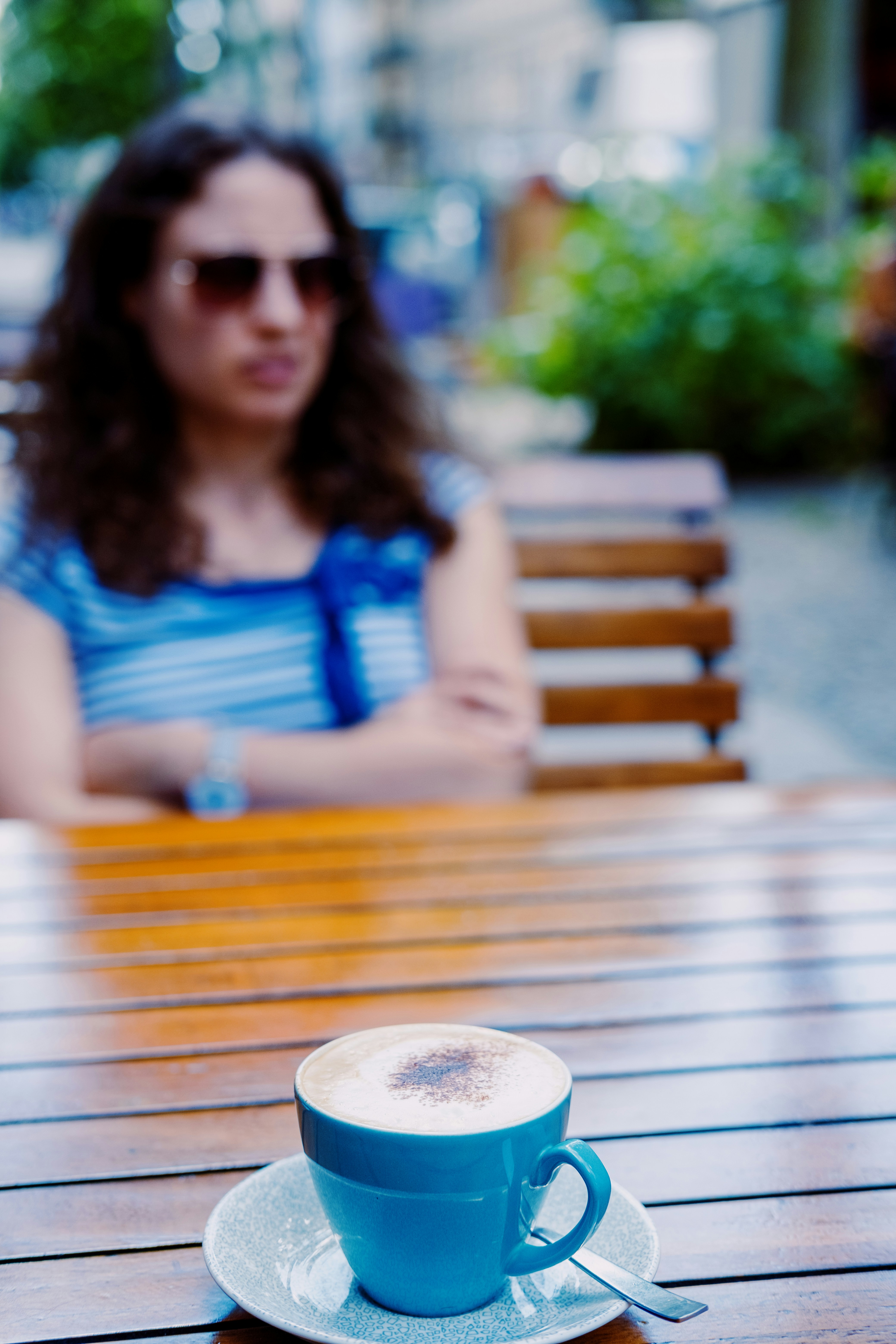 Blue Cup on Sunlit Wood: Afternoon Café Blur