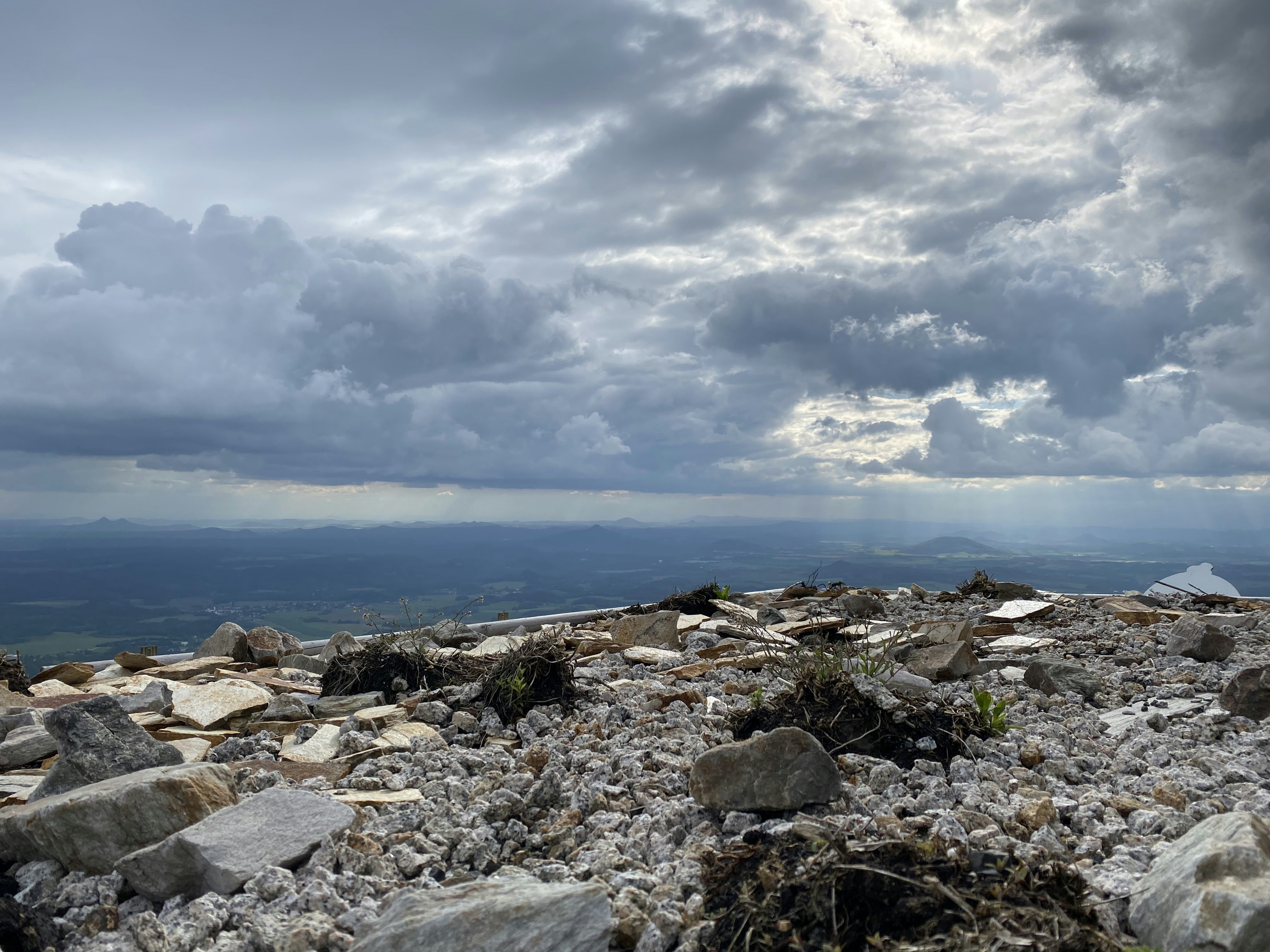 Rocky landscape beneath dramatic, cloud-filled sky during daytime.