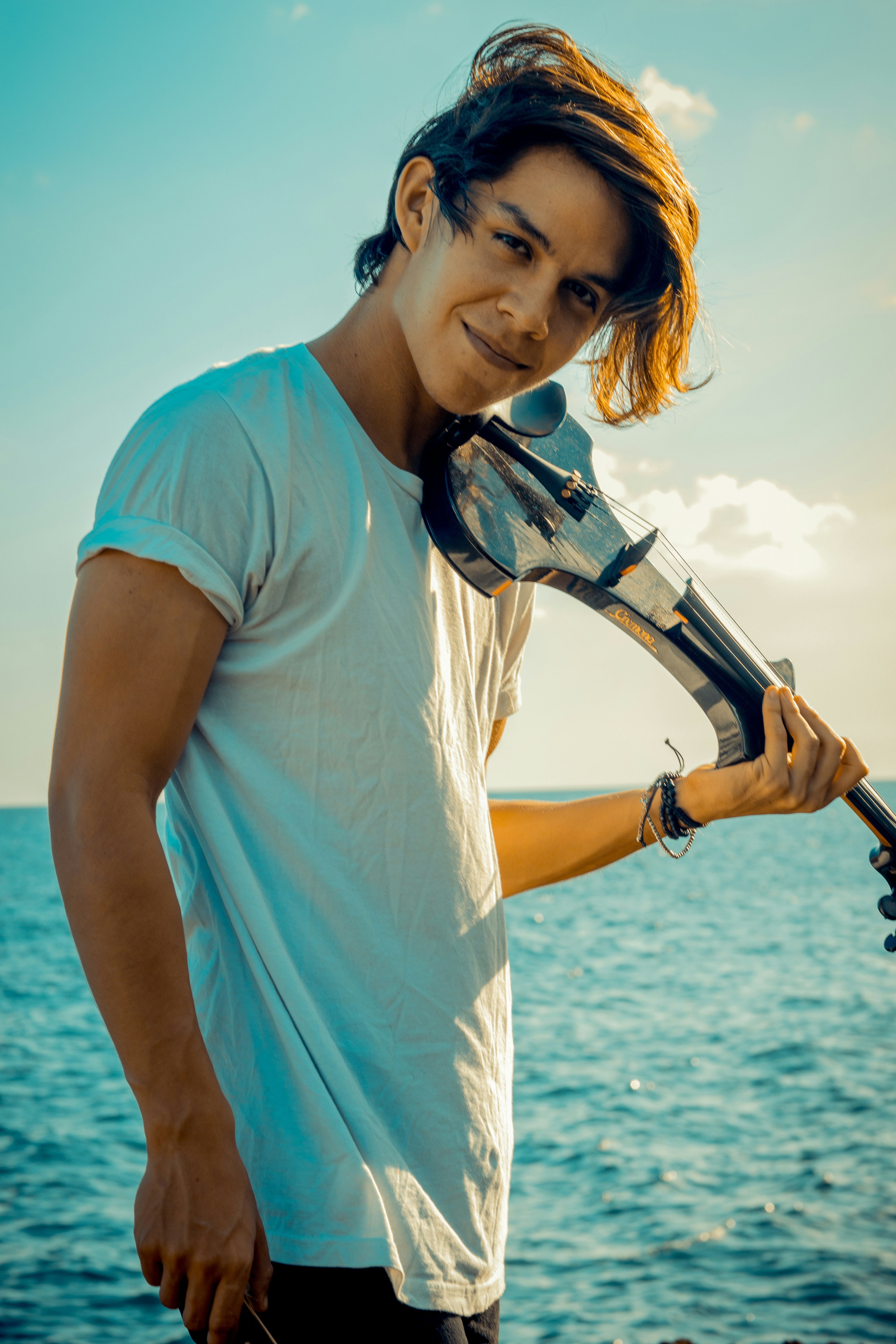 Seaside Serenade: a sunlit violinist by the horizon