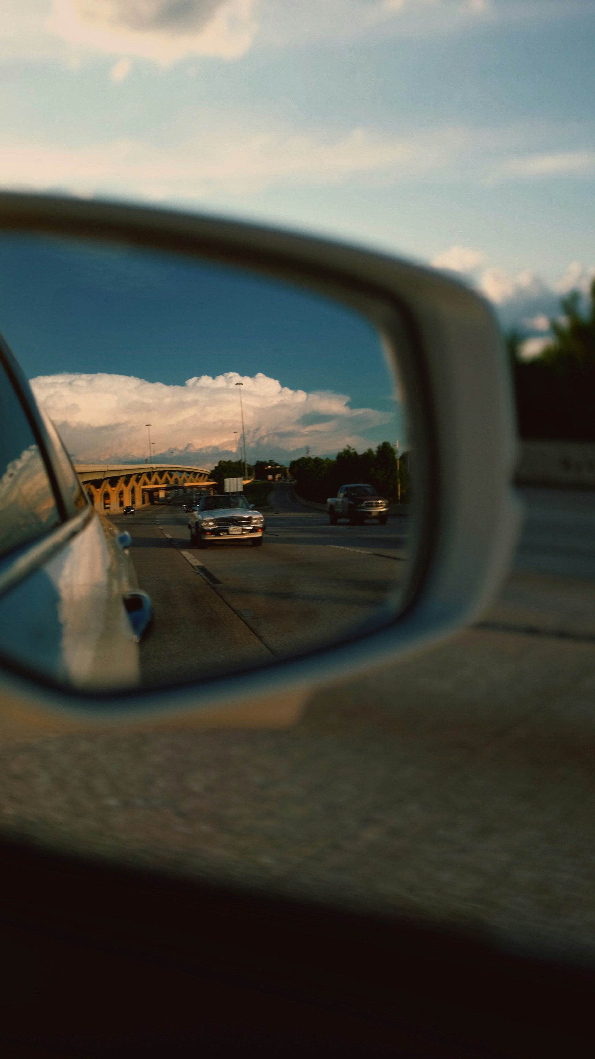 Side Mirror Vista: A White Car on the Moving Highway