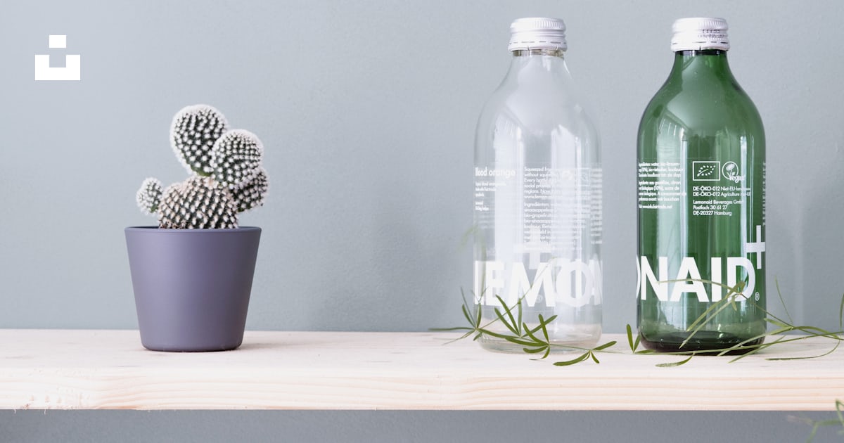 Green Glass Bottle Beside Blue Ceramic Cup Photo Free Bottle Image On