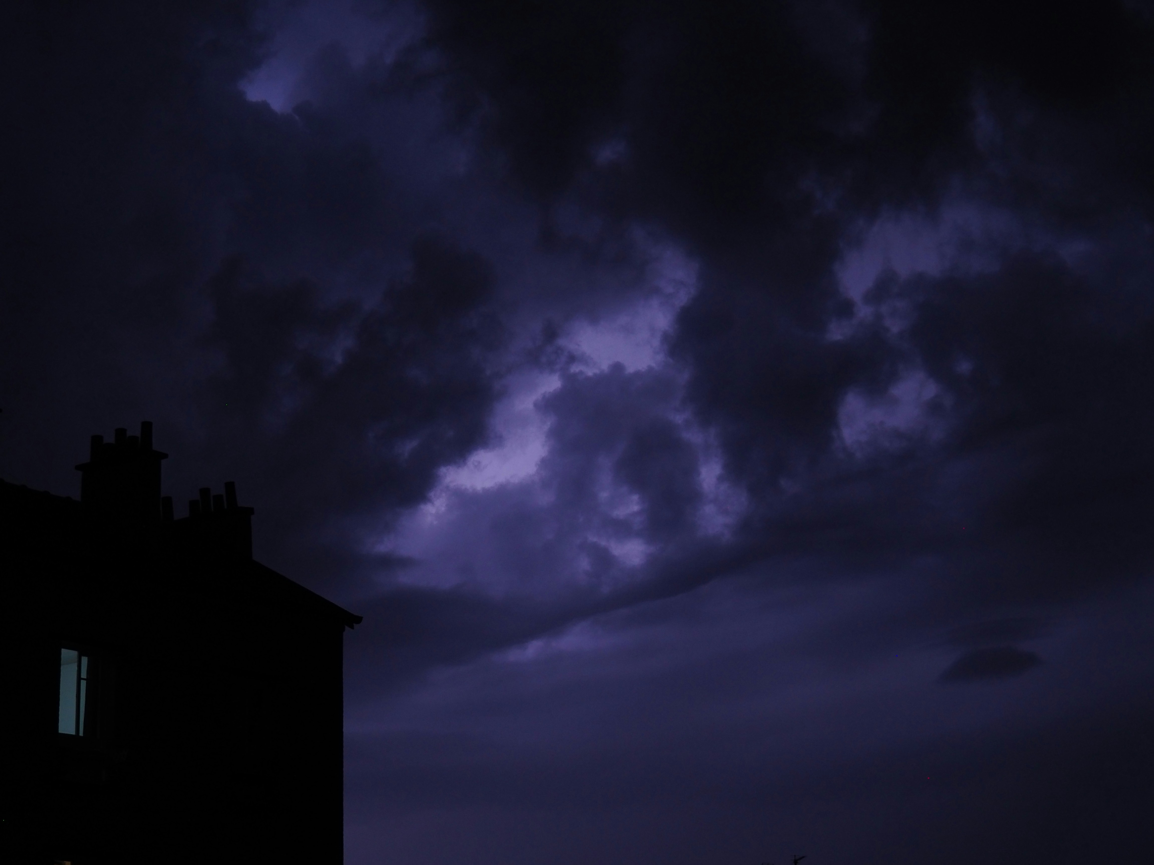 Violet Storm over a Silent Rooftop Silhouette