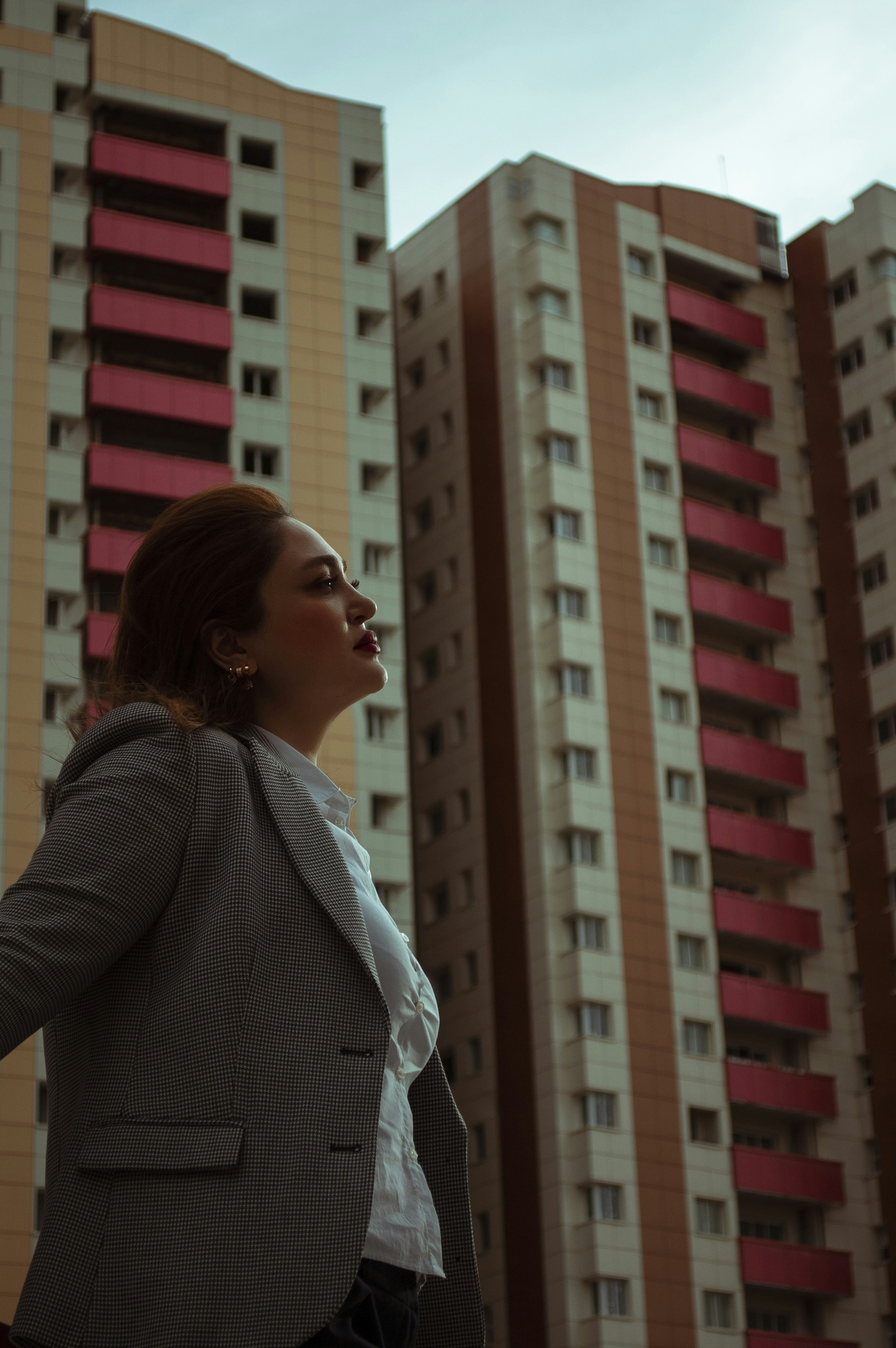 City silhouette and the confident stride: portrait against a red-bricked skyline