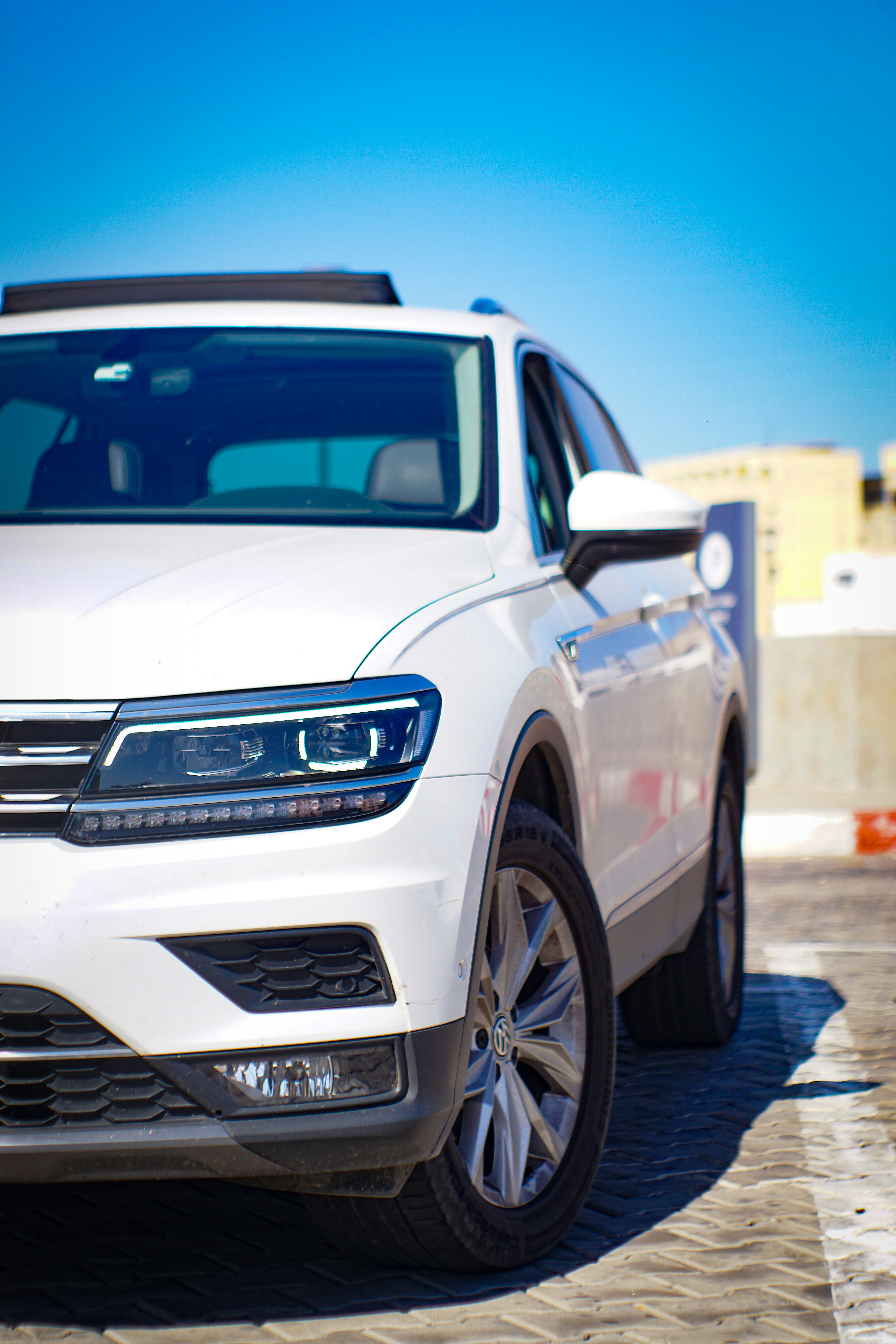 Front-Quarter Perspective of a White SUV in a Sunlit Parking Lot