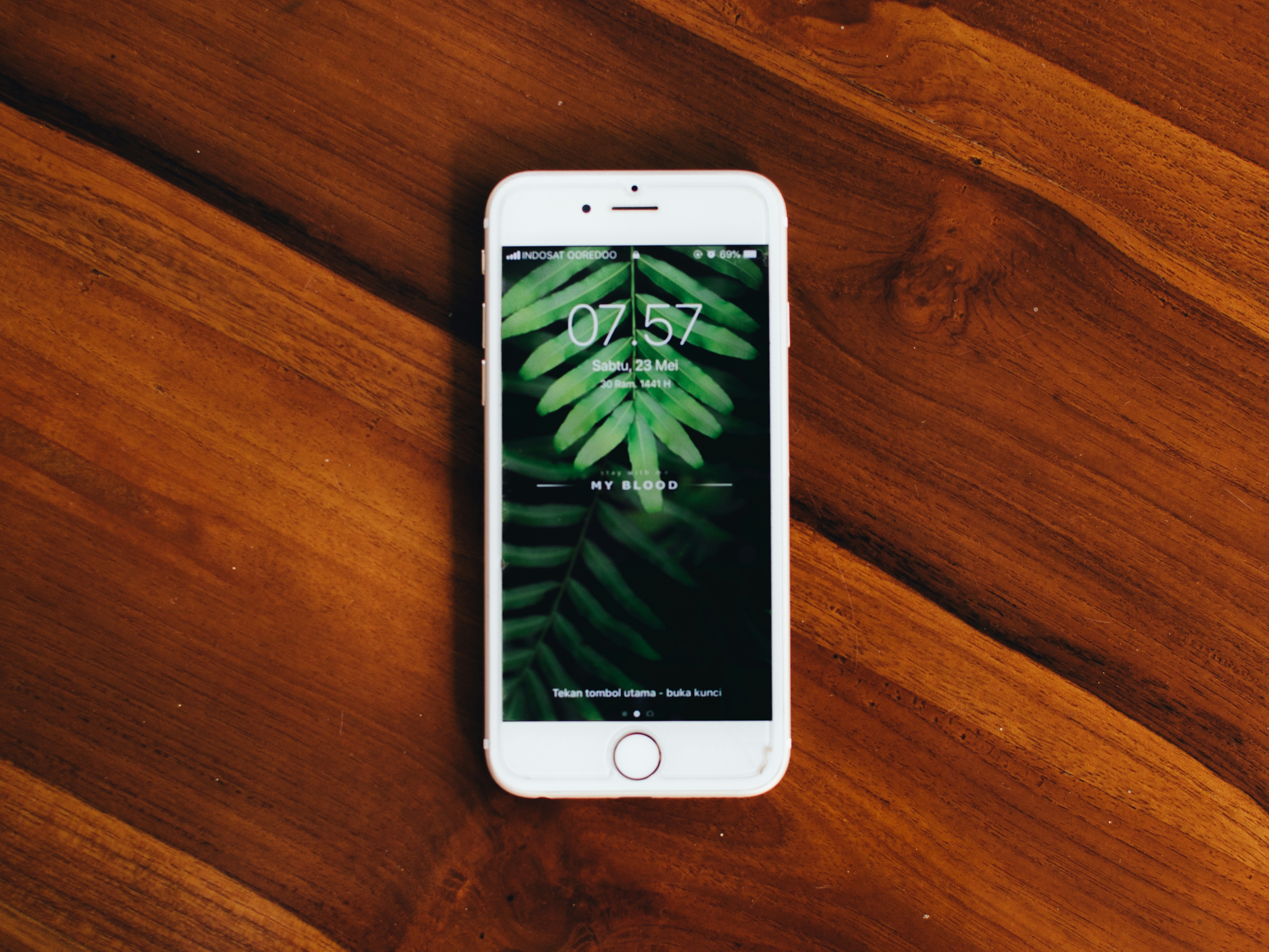 Neatly lit iPhone resting on a glossed wooden surface