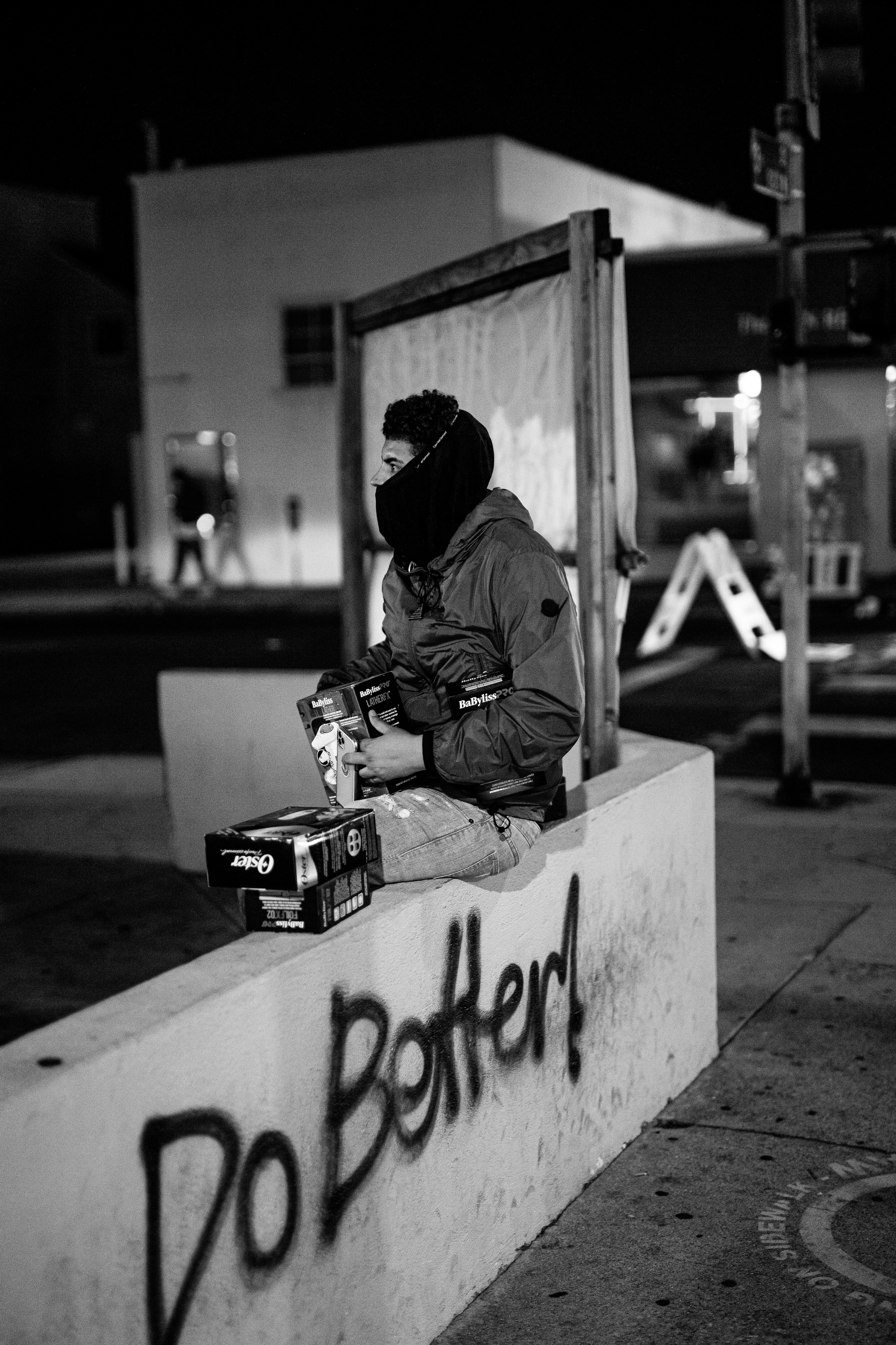 Man in brown jacket and black knit cap sitting on concrete bench photo ...