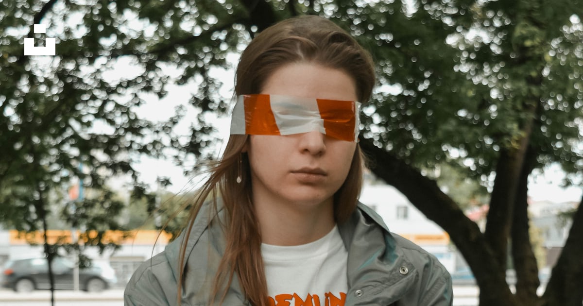 昼間、茶色の木製のベンチに座っている灰色のパーカーを着た女性の写真 Unsplashのロシコの無料画像