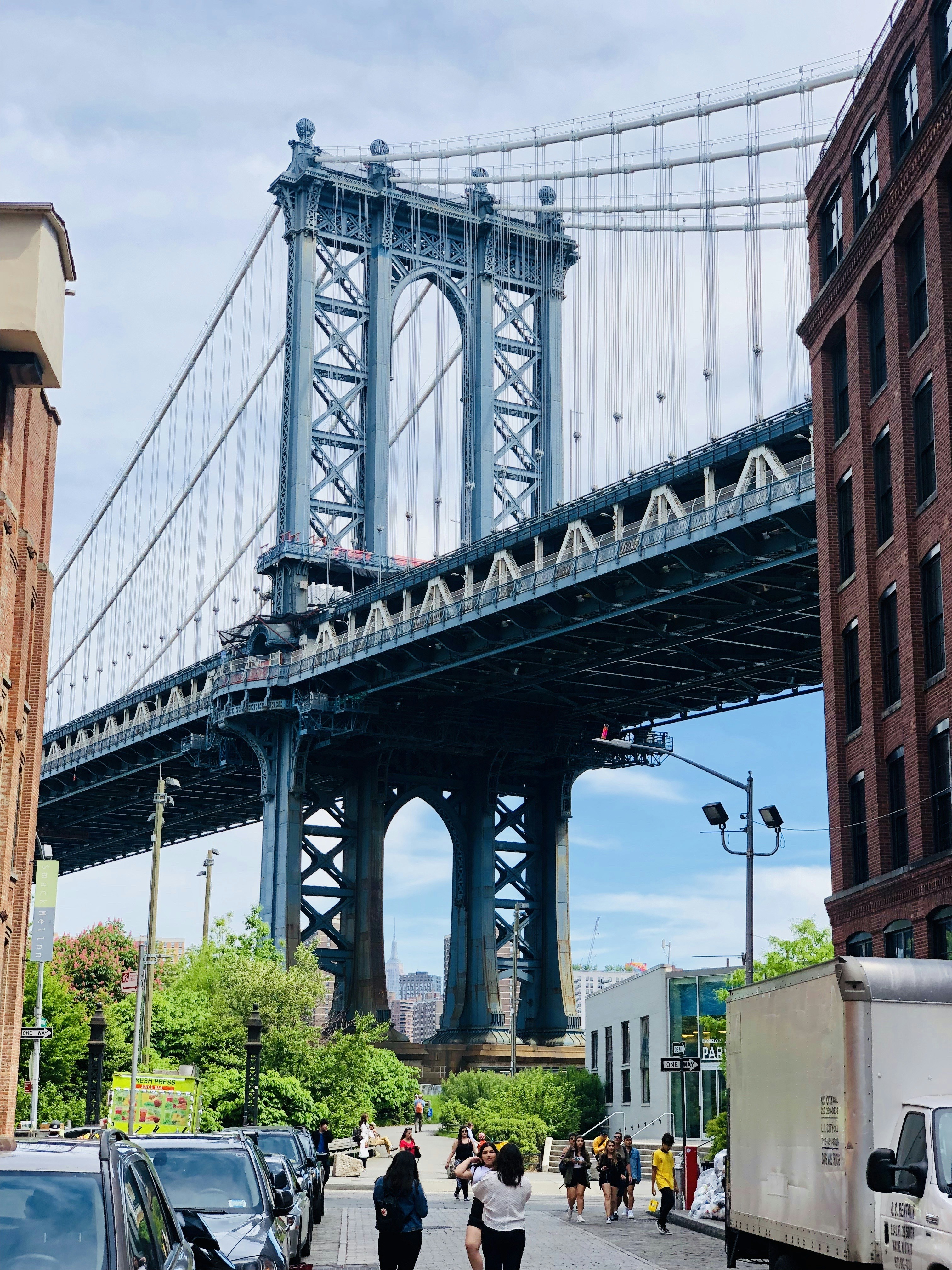 Steel Giants Over a Pedestrian Lane: Brooklyn Bridge Framed by Urban Life