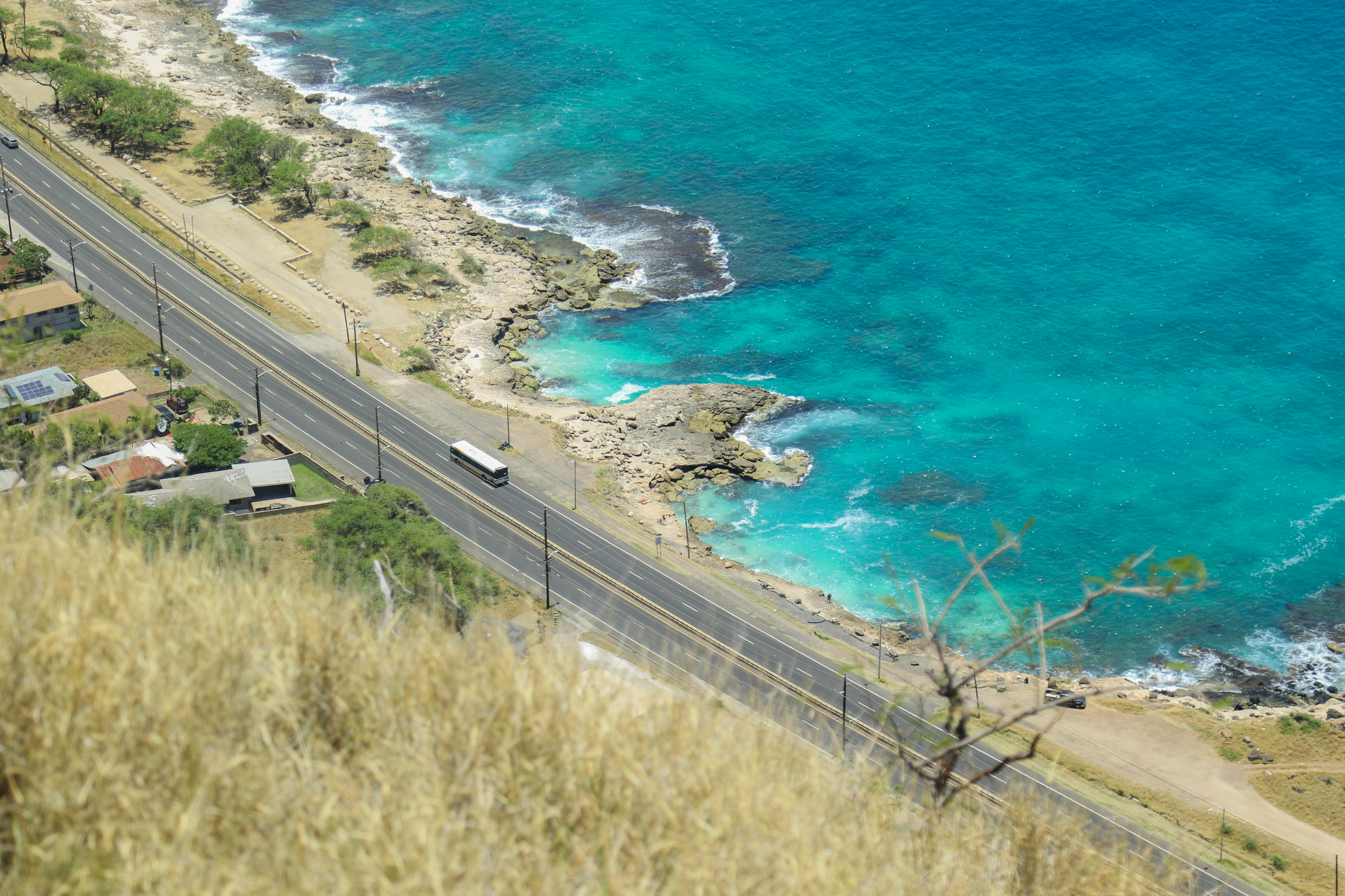 Coastal Highway Over Turquoise Waters: A Lone Bus Traces the Cliffside Bend