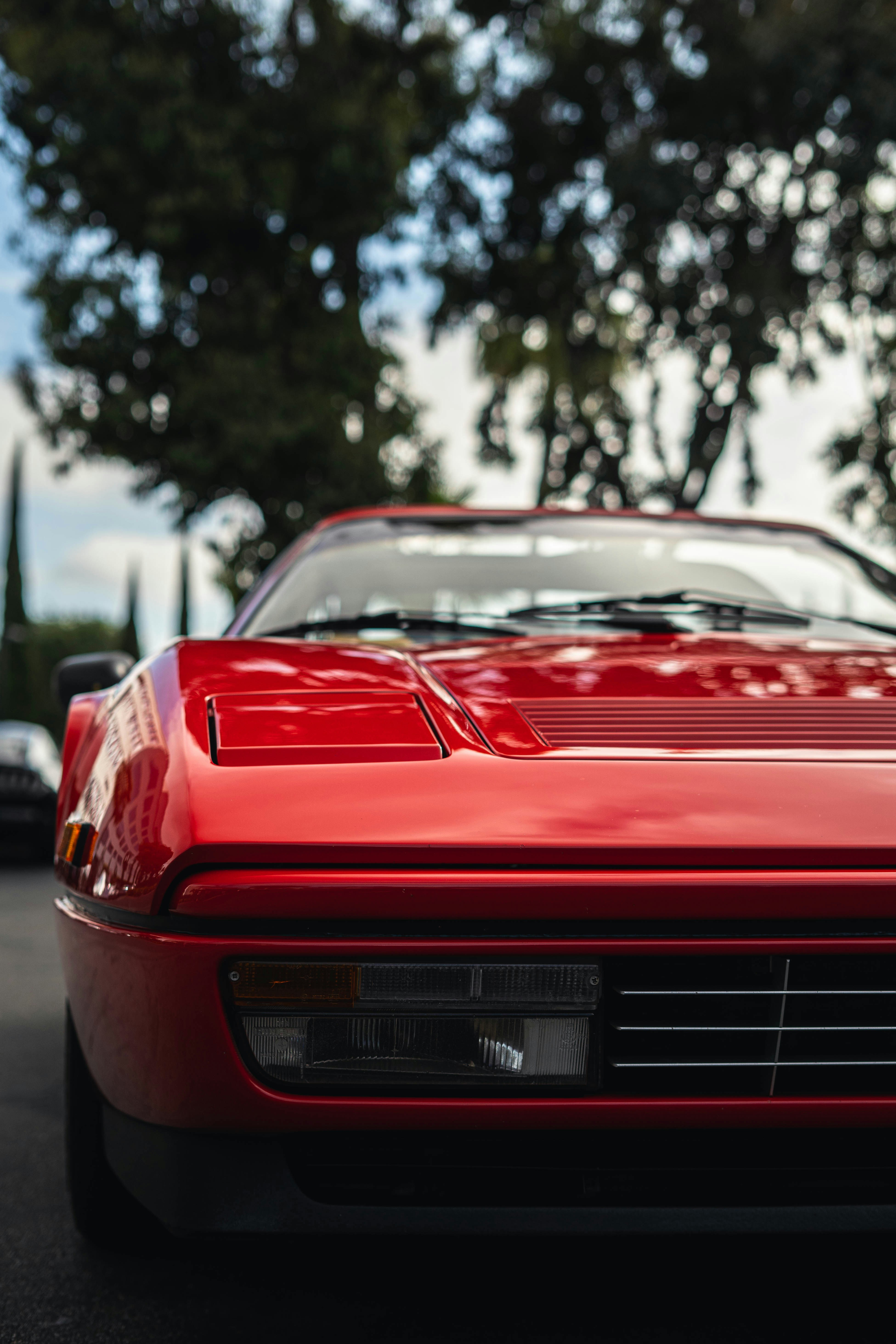 Chevrolet Camaro rouge garée près d’arbres verts pendant la journée ...