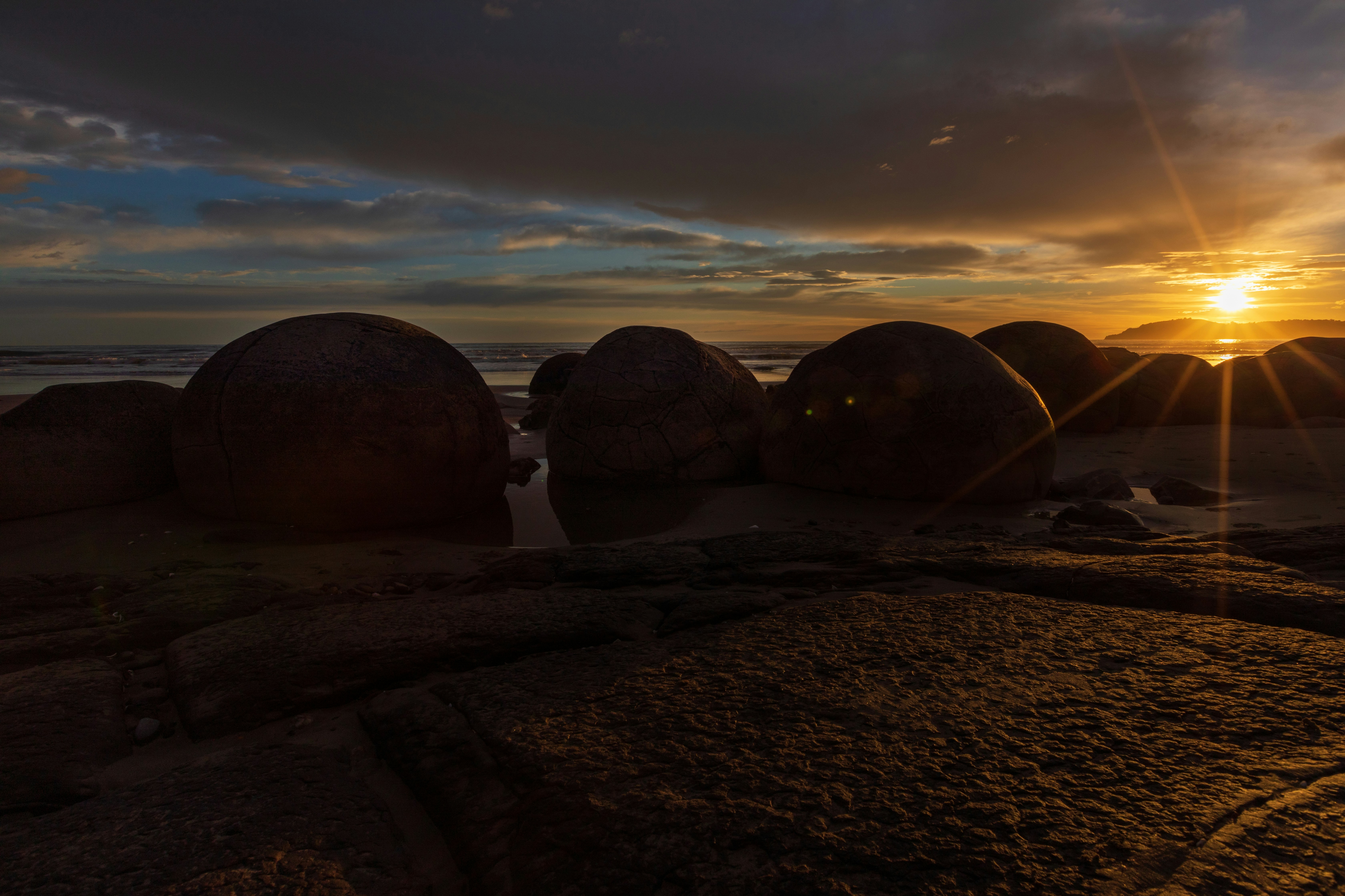 Sunrise Over Weathered Spheres: Tide-Touched Boulders on Silent Shore