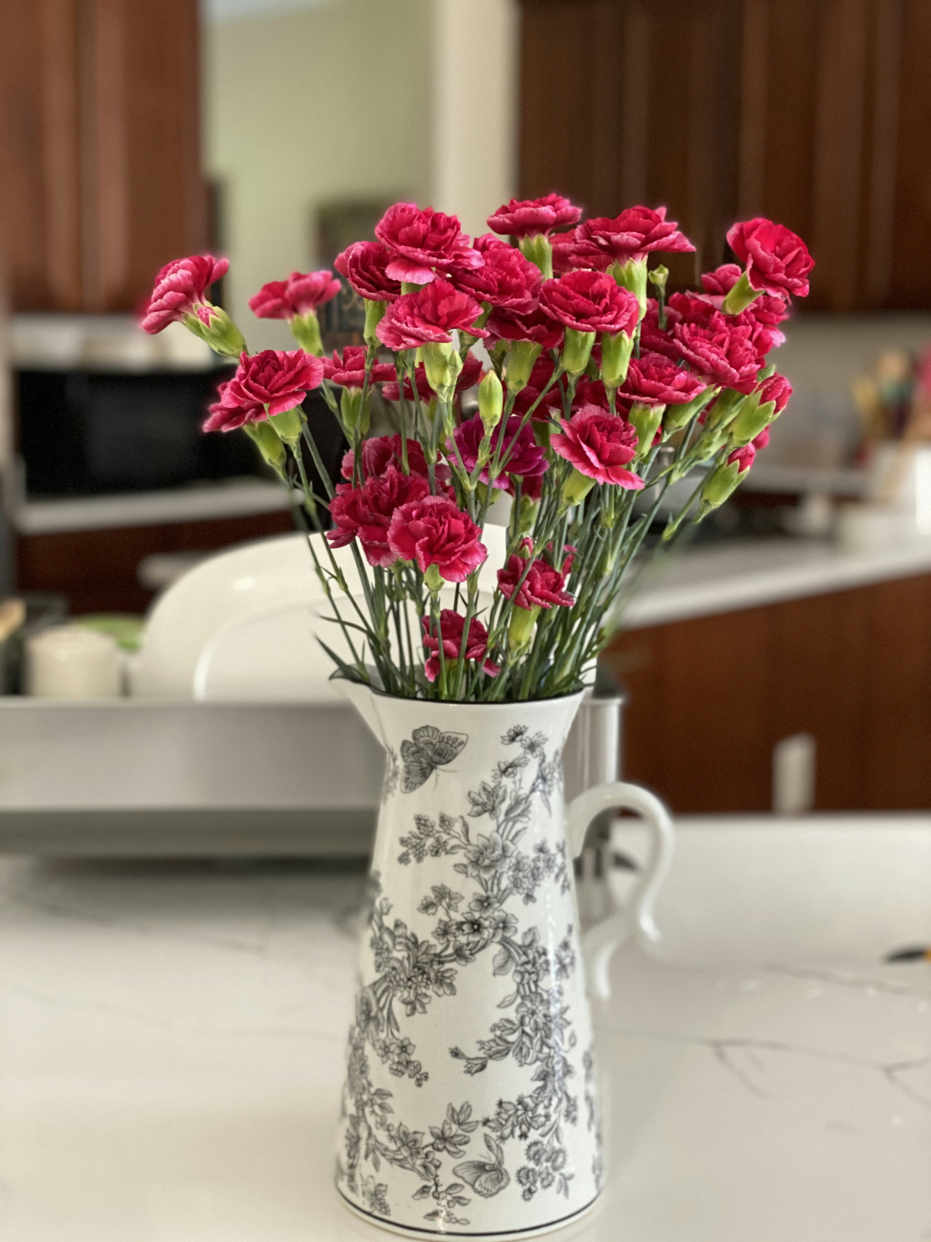 Crimson Bouquet in a Floral Pitcher on a Marble Kitchen Counter