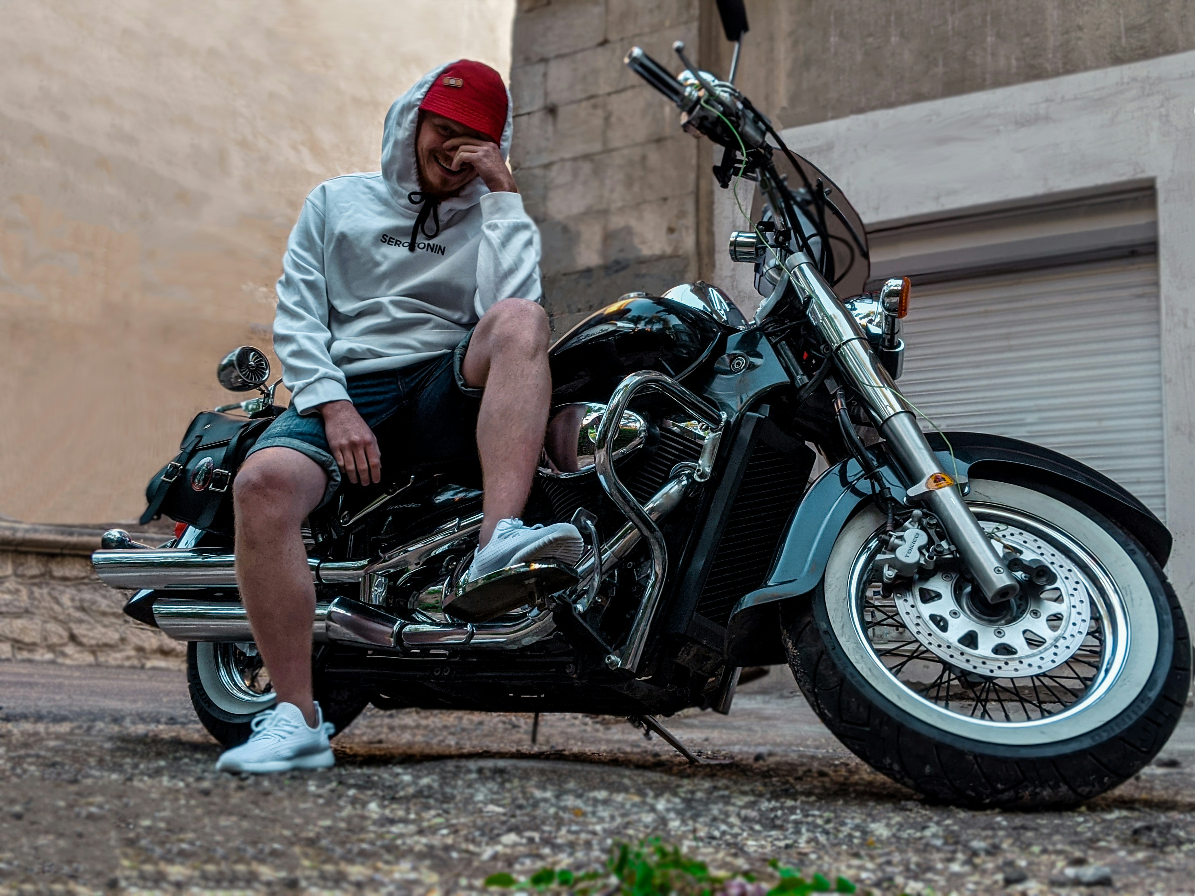 Hooded Rider on a Chrome Motorcycle in a Quiet Urban Alley