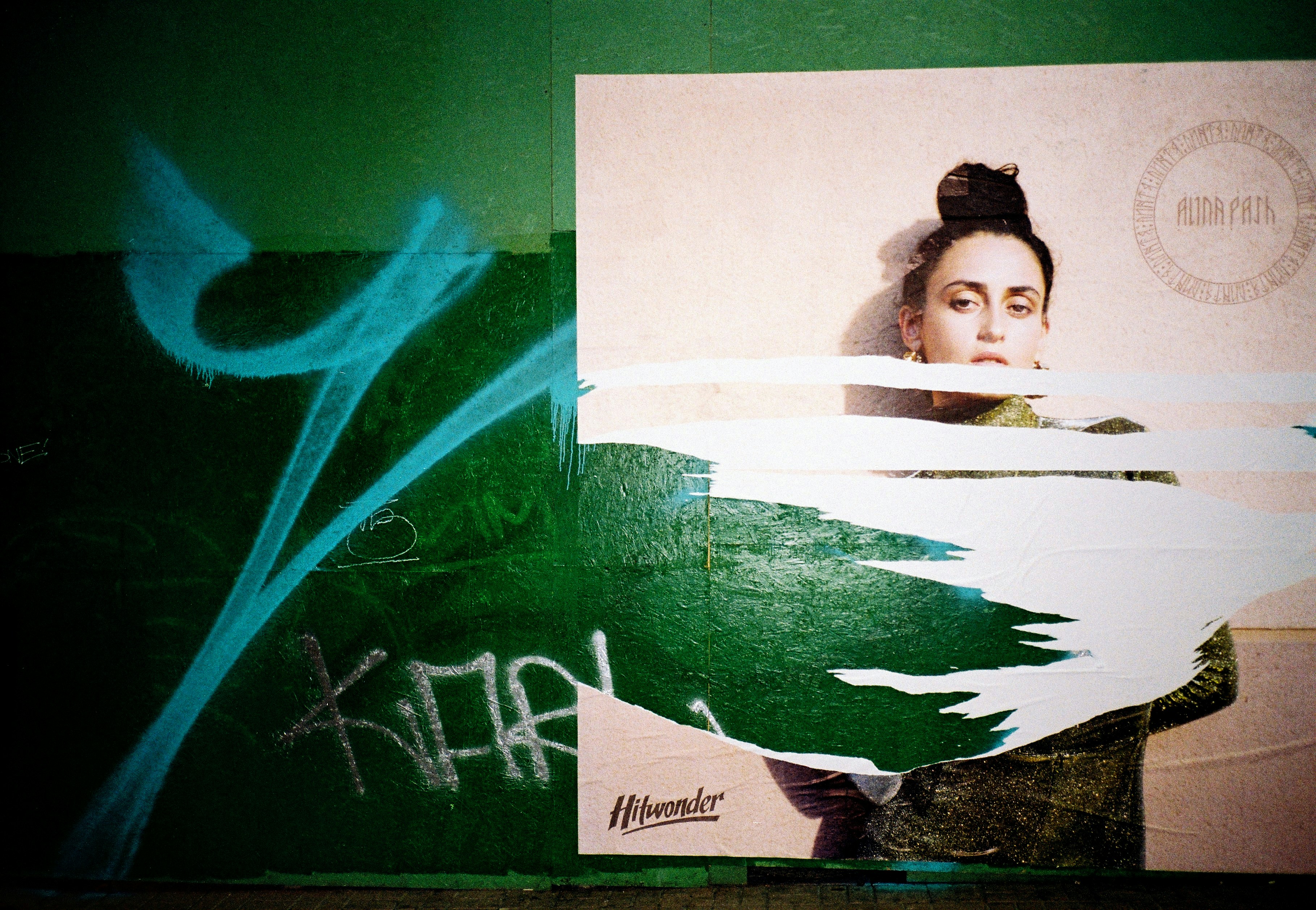 Masked by Stripes: a Portrait Peeks Through Torn Advertisement