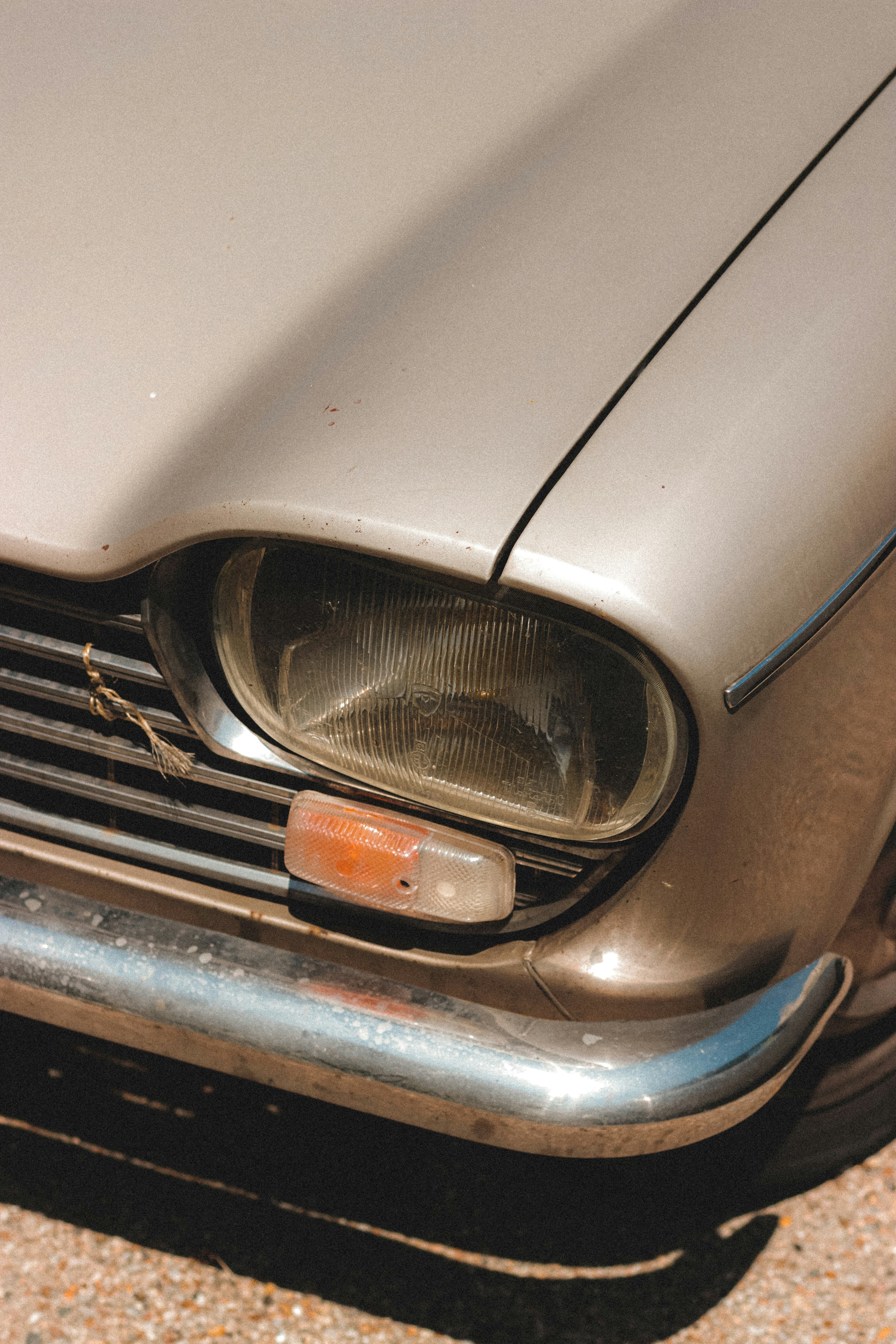 Chrome Gaze: A Close-Up of a Weathered Vintage Car's Headlamp