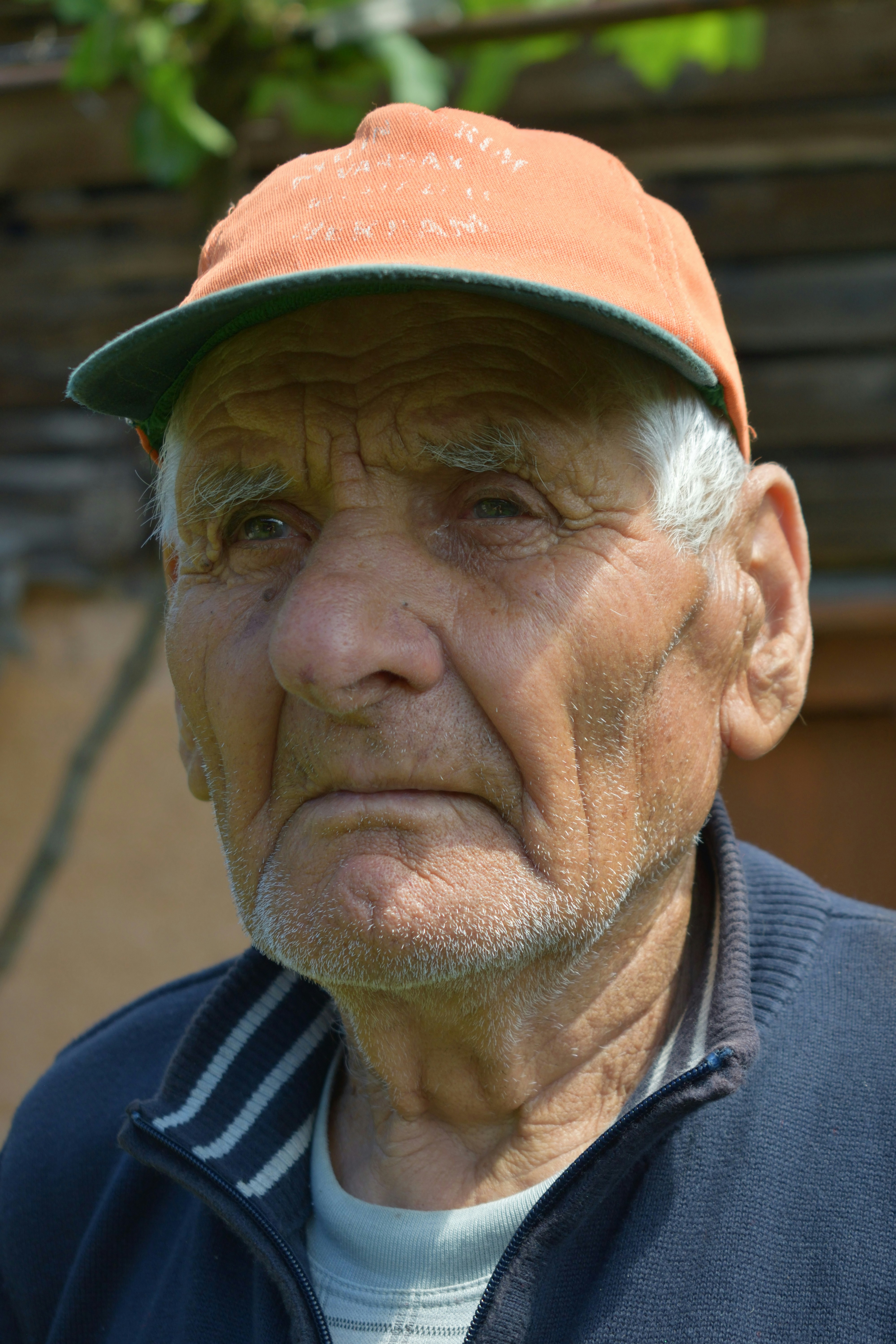 Man in blue and white striped polo shirt wearing orange cap photo ...