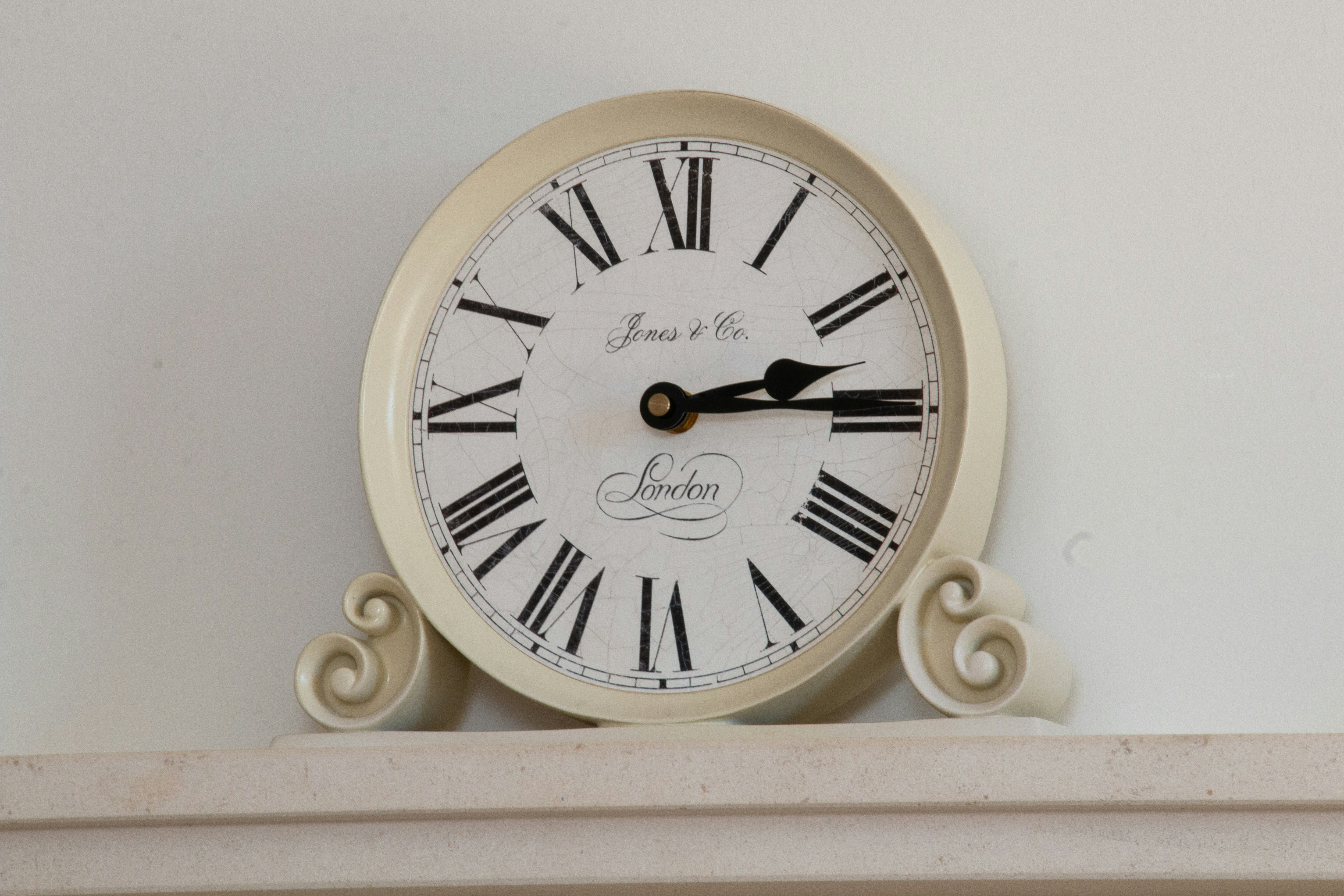 Ivory Timekeeper with Roman Numerals on a Scrollwork Mantel