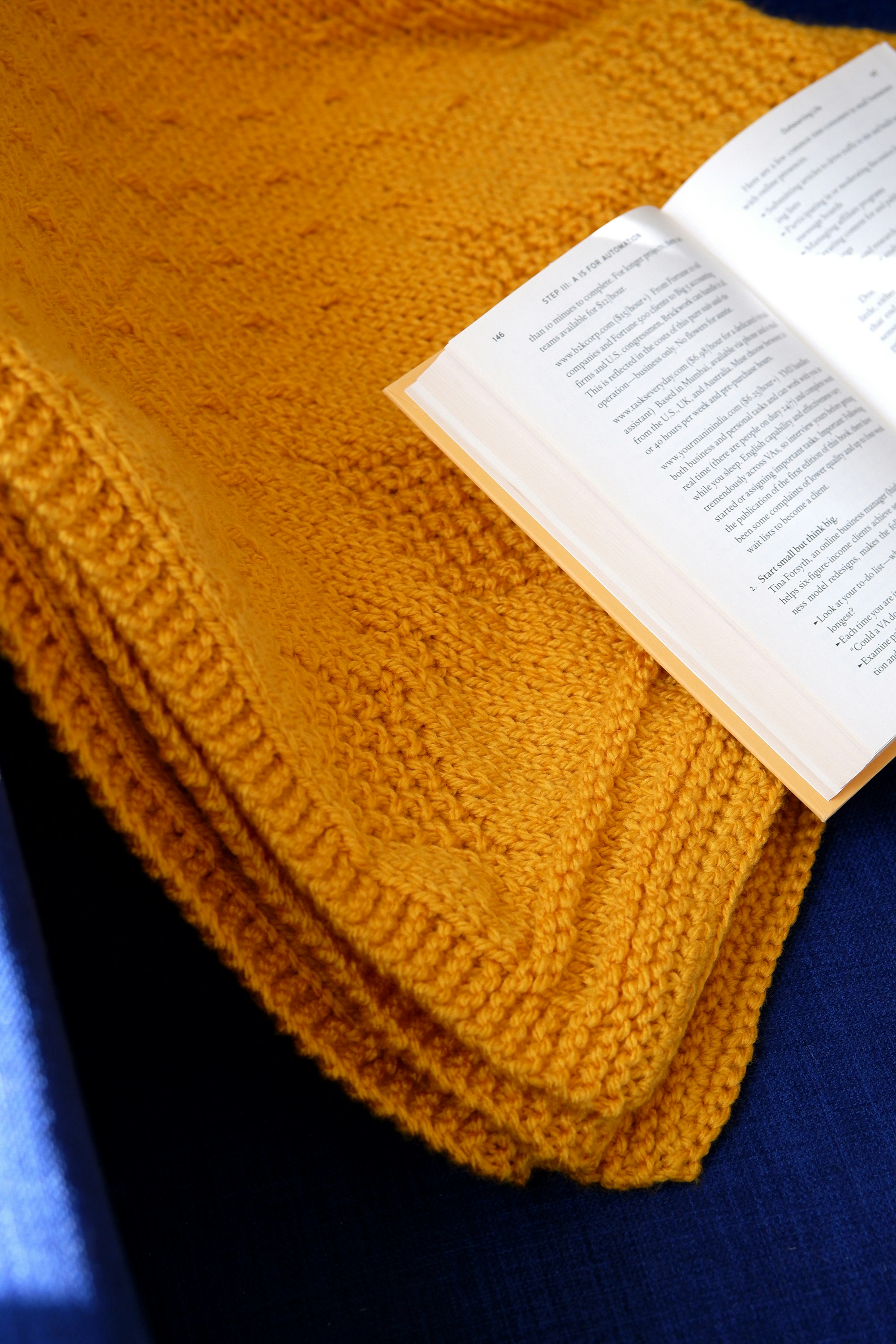 Golden Knit and Open Page: A Quiet Moment in Textured Light