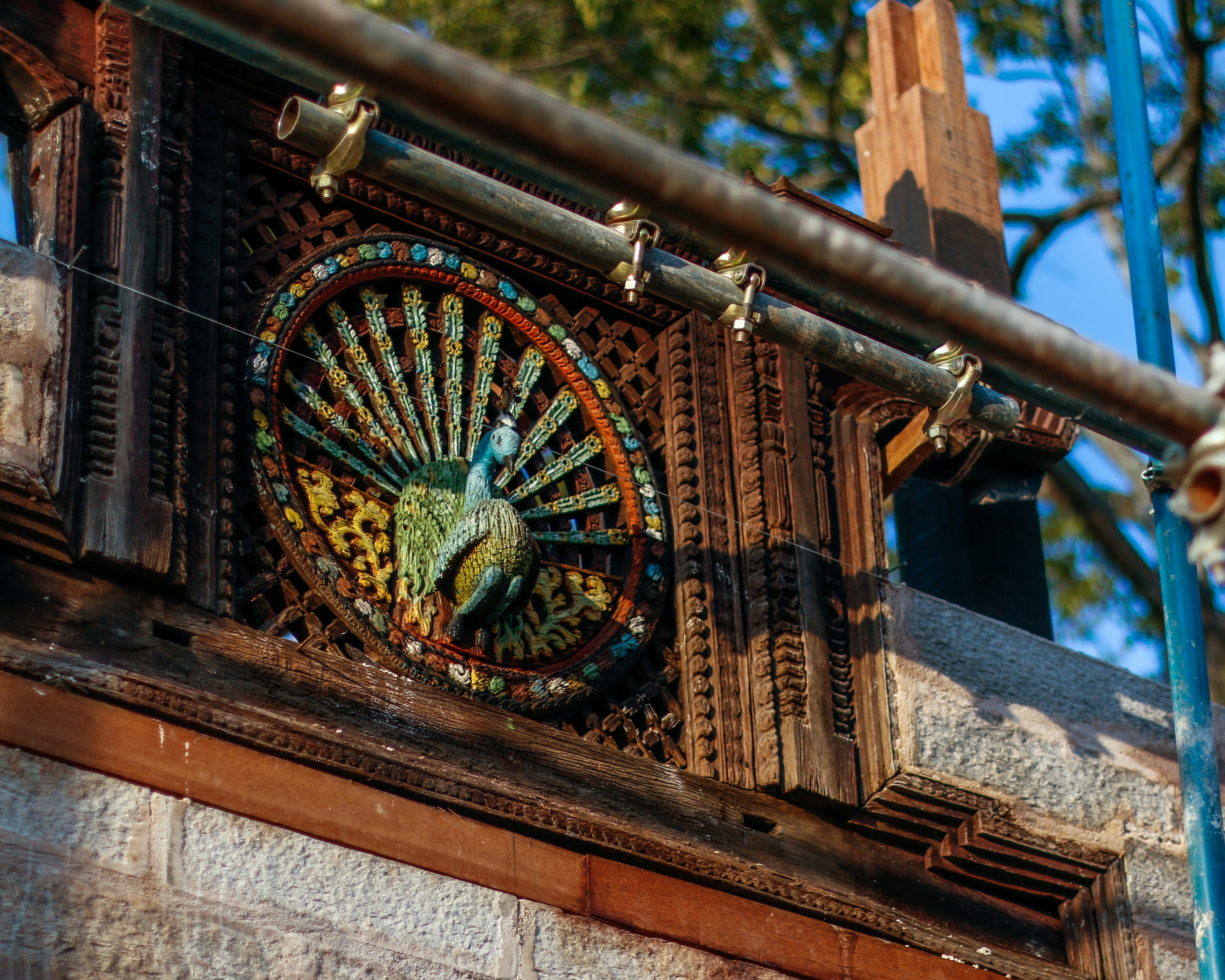 Peacock Mosaic Crown: Circular Crest Framed by Intricate Wood Carving