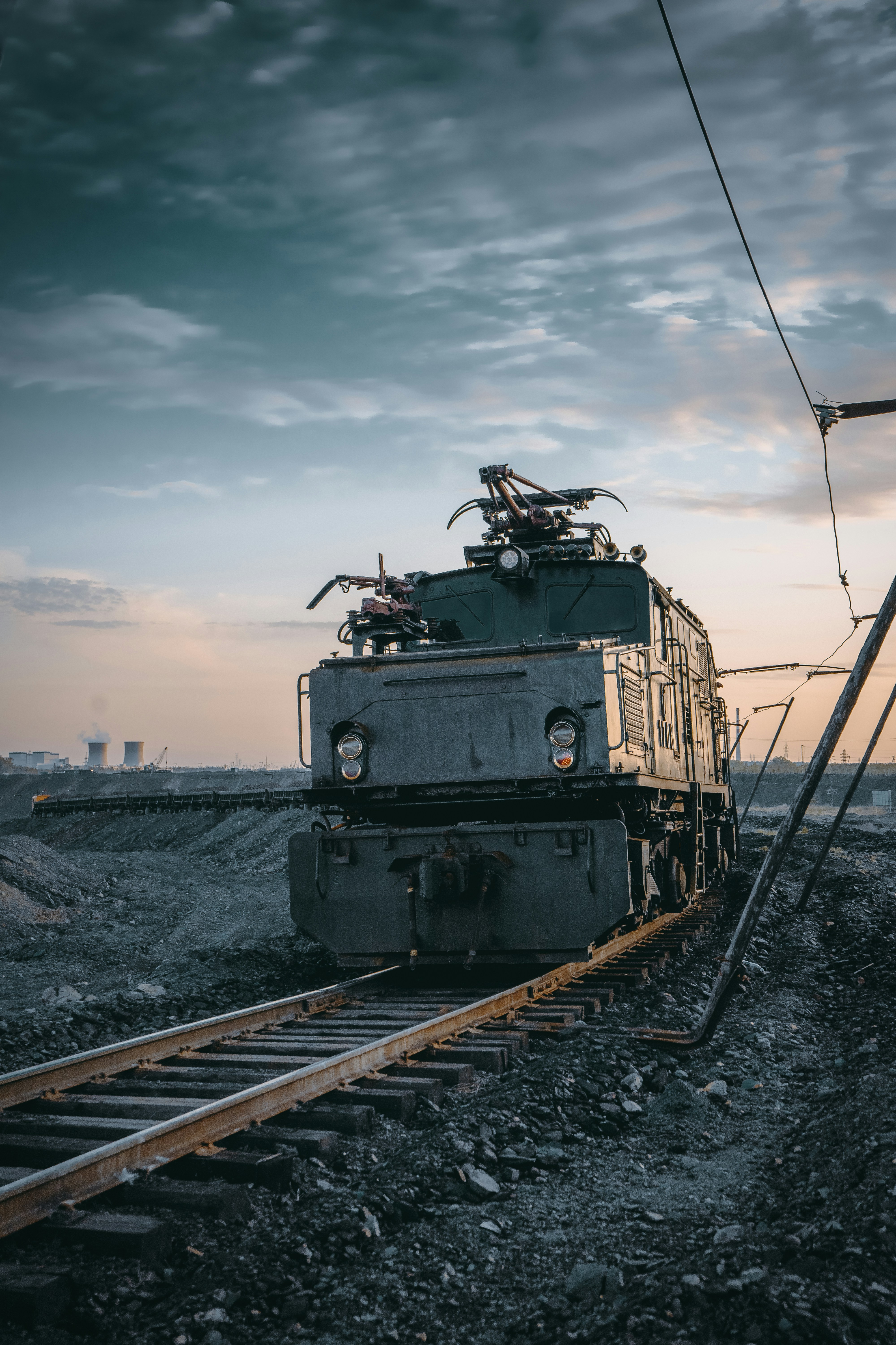 Green and black train on rail tracks under cloudy sky during daytime ...