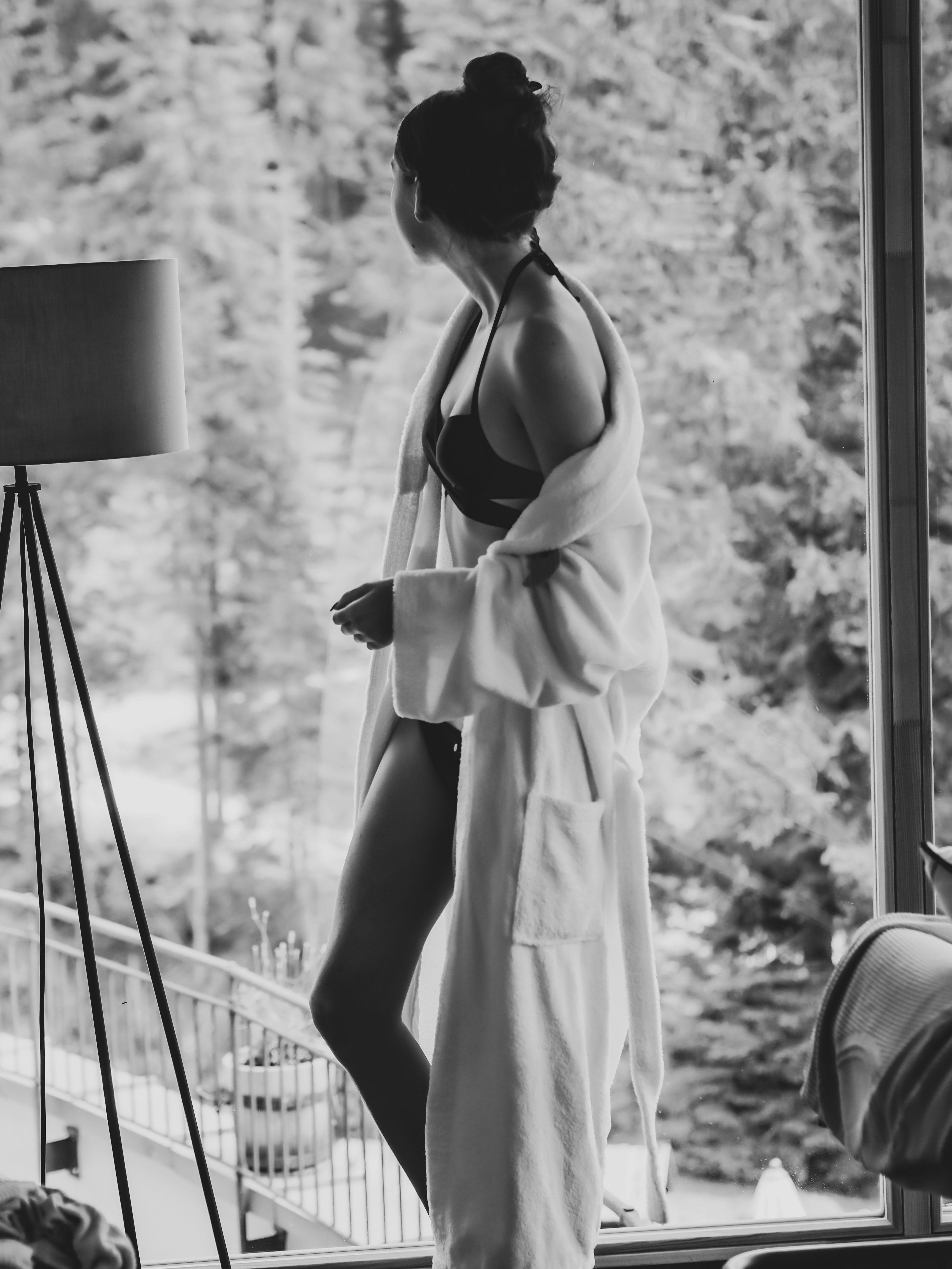Silhouetted Evening Calm: A Woman in a Bathrobe by the Window