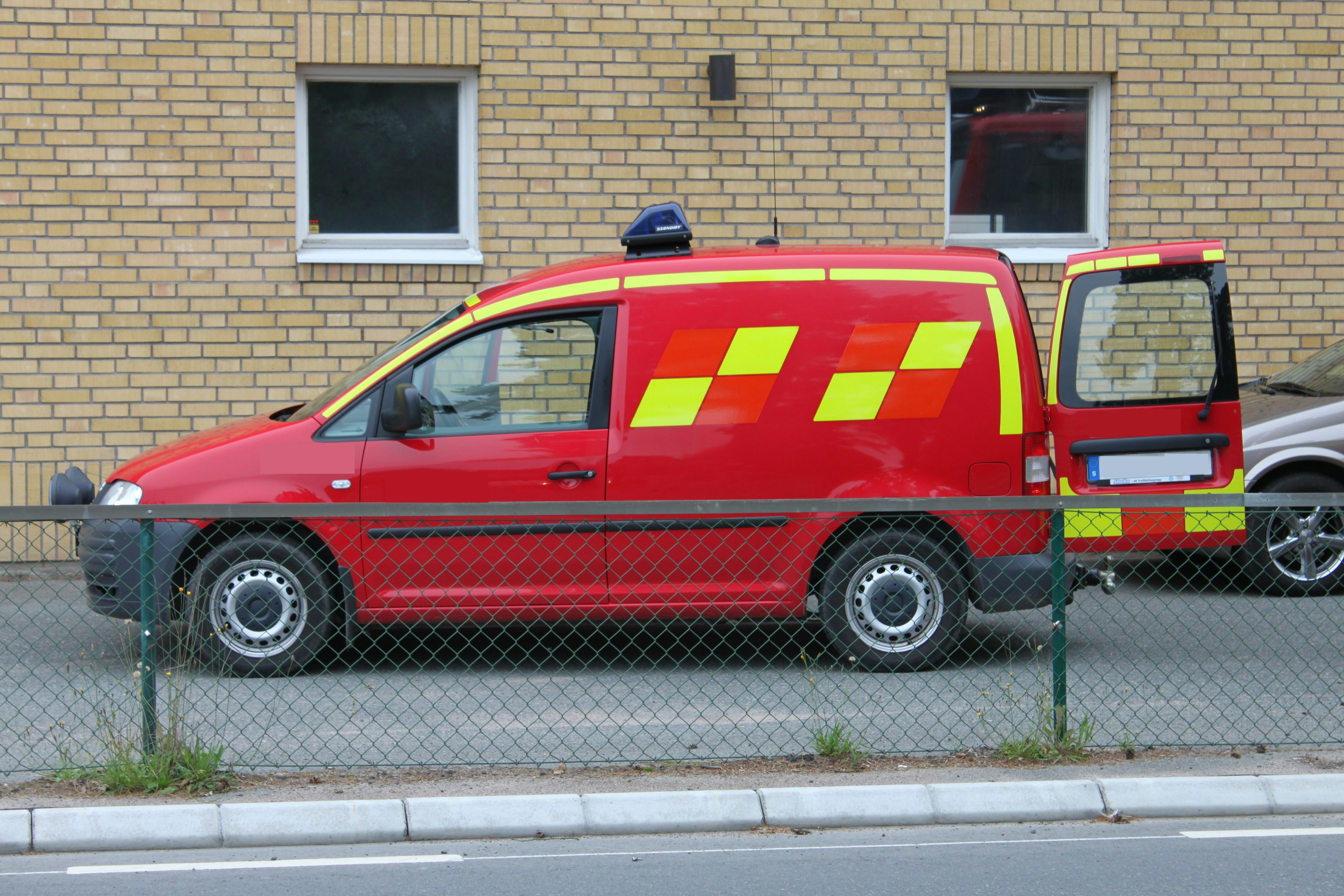 Urban Red Rescue Van with High-Visibility Chevron in Quiet Street