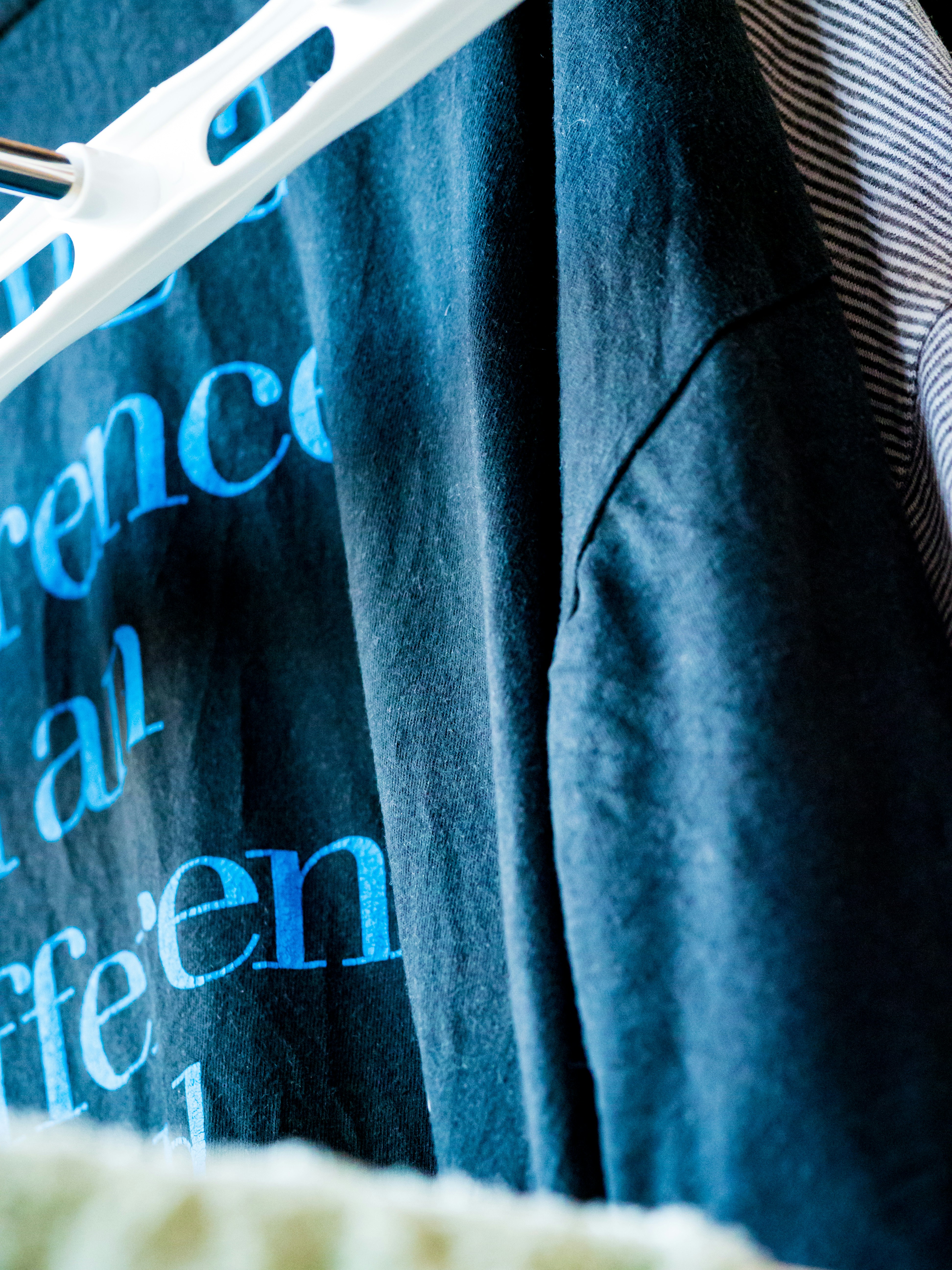 Blue Velvet Garment on a White Hanger, Framed by Deep Textured Folds