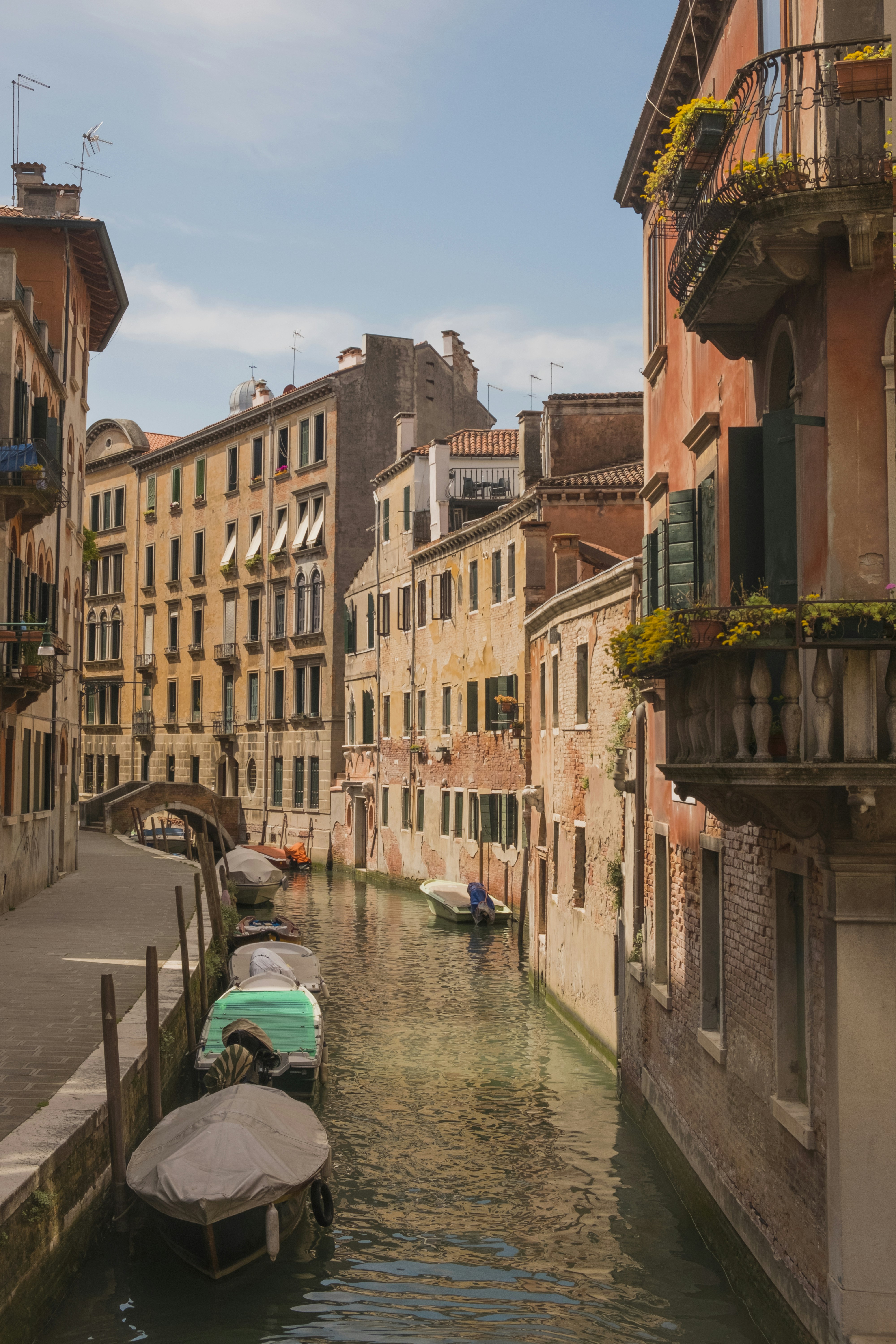 Morning Light Along a Venetian Canal: Facades, Boats, and a Distant Bridge