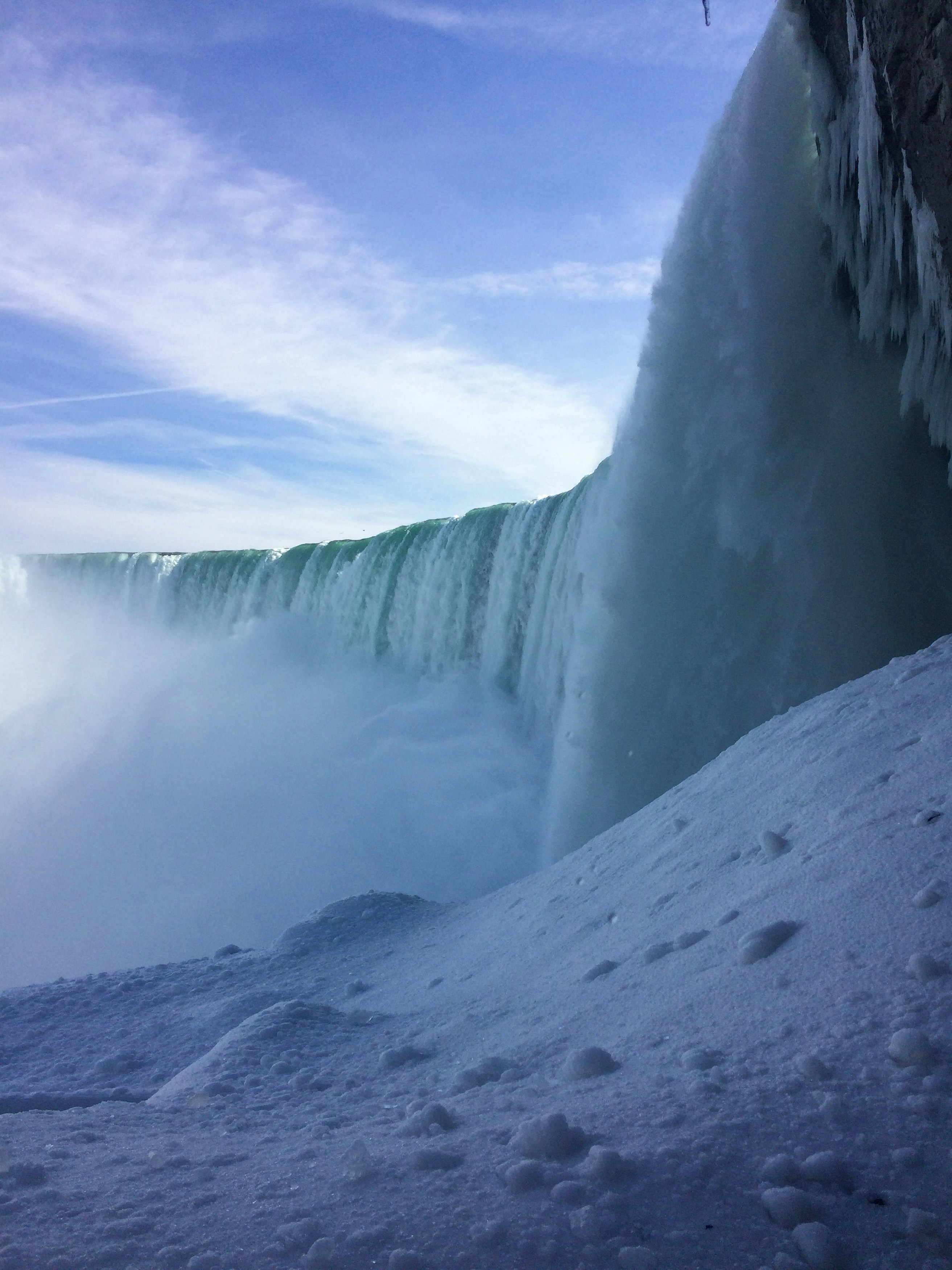 Turquoise Curtain over the Ice Cliff: A Snowbound Cascade